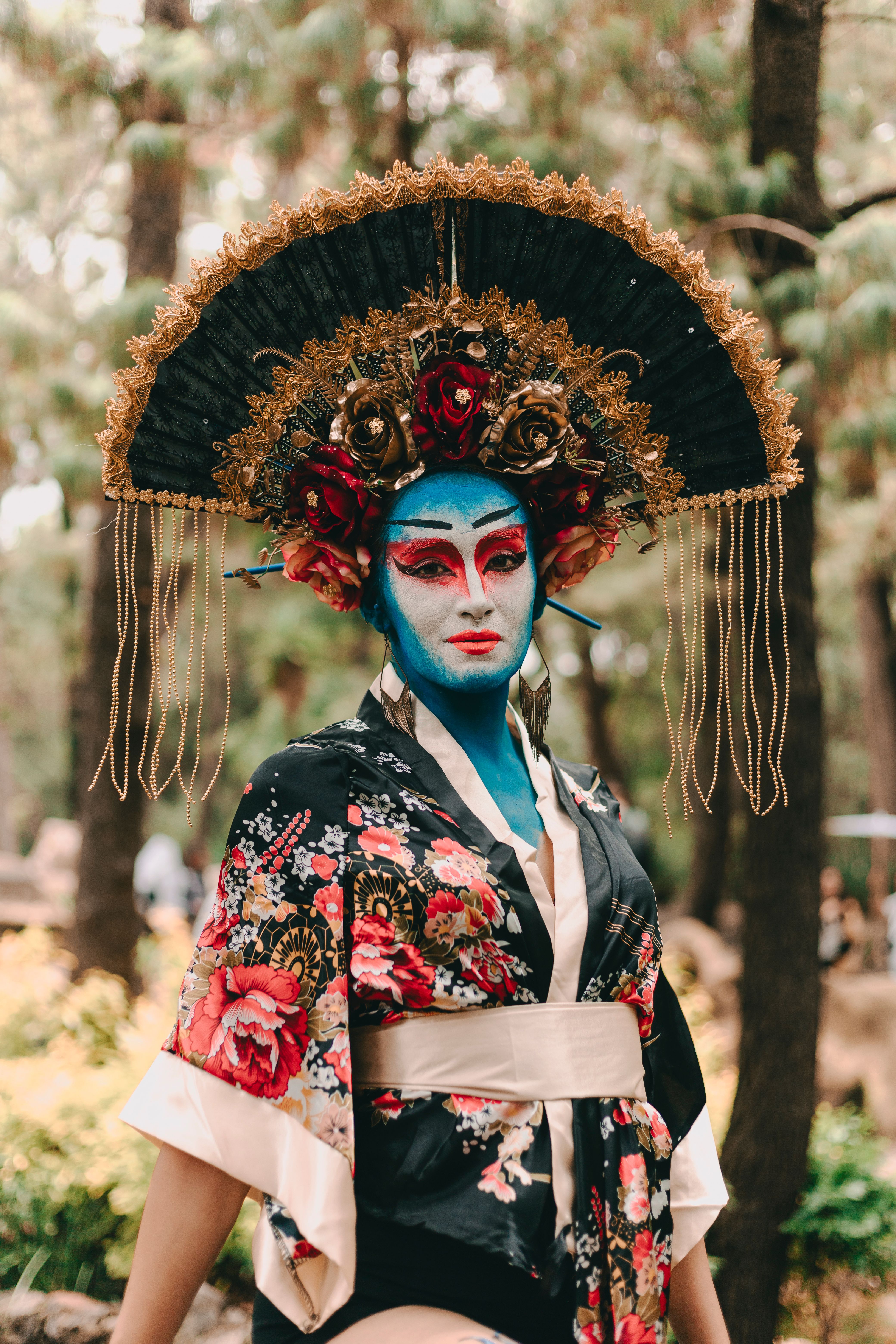 A woman in a blue and black costume with a face painted · Free Stock Photo