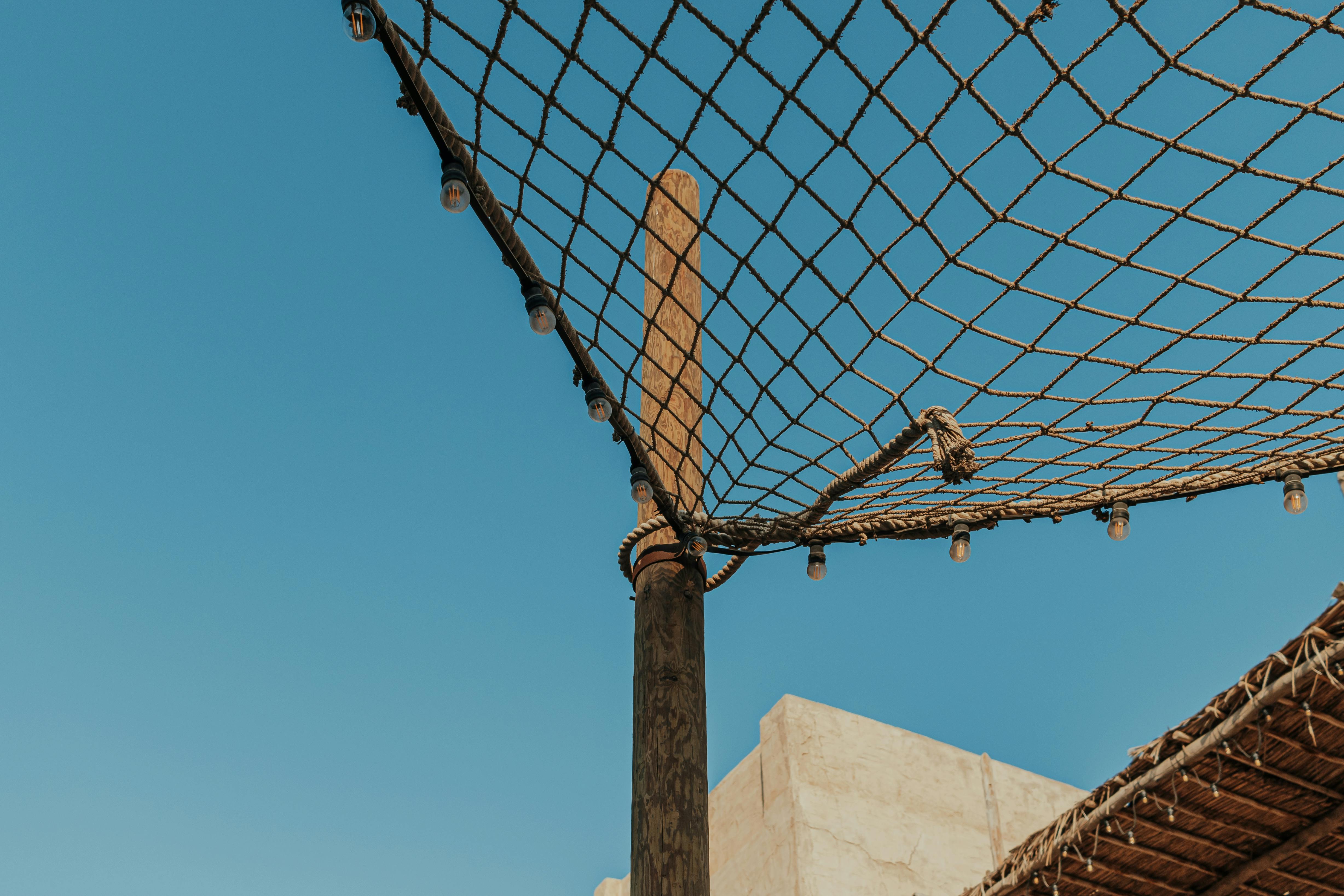 Decorative rope netting and string lights outdoor with blue sky on the ...