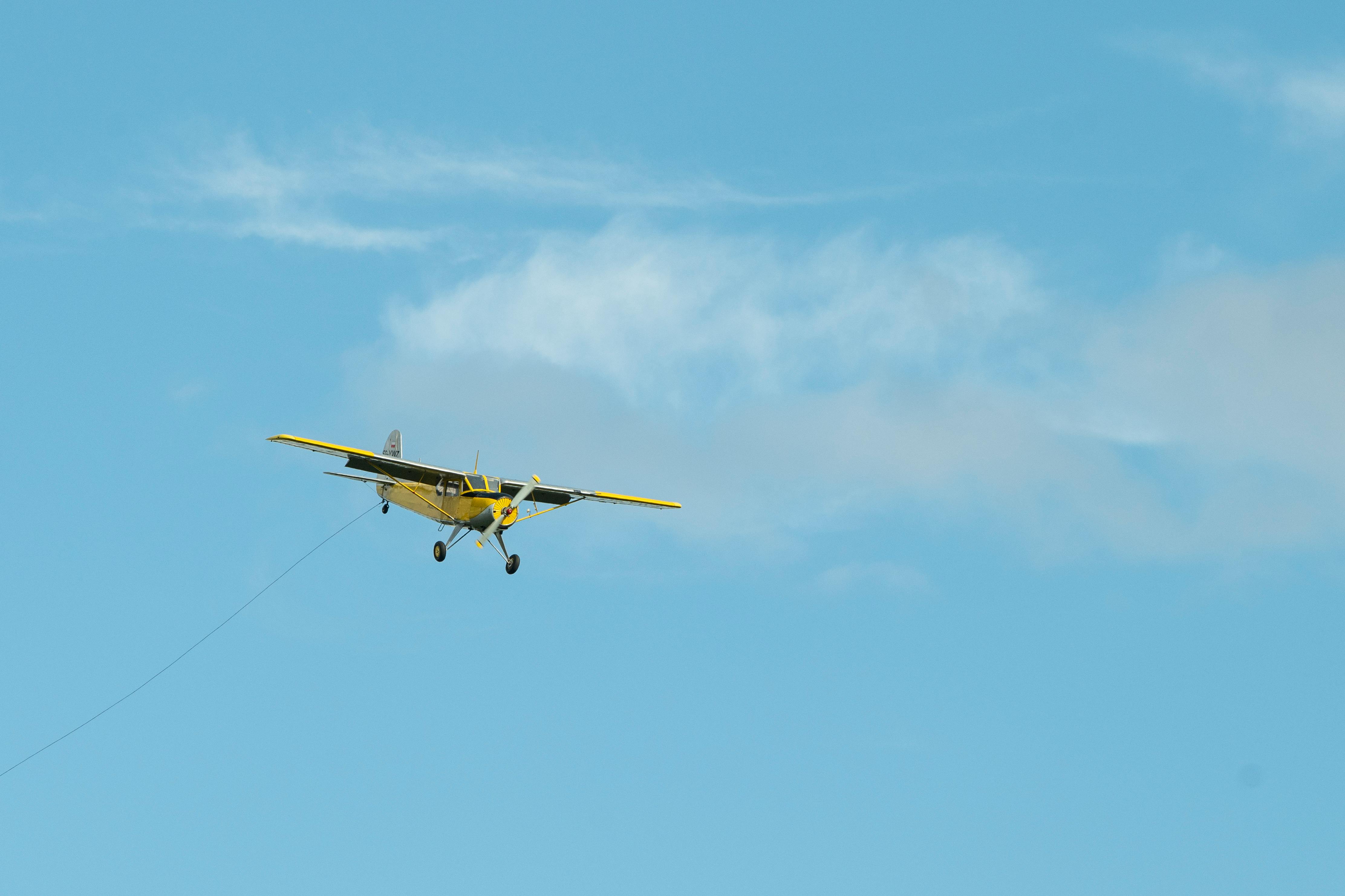 A small airplane flying in the sky with a parachute attached · Free ...