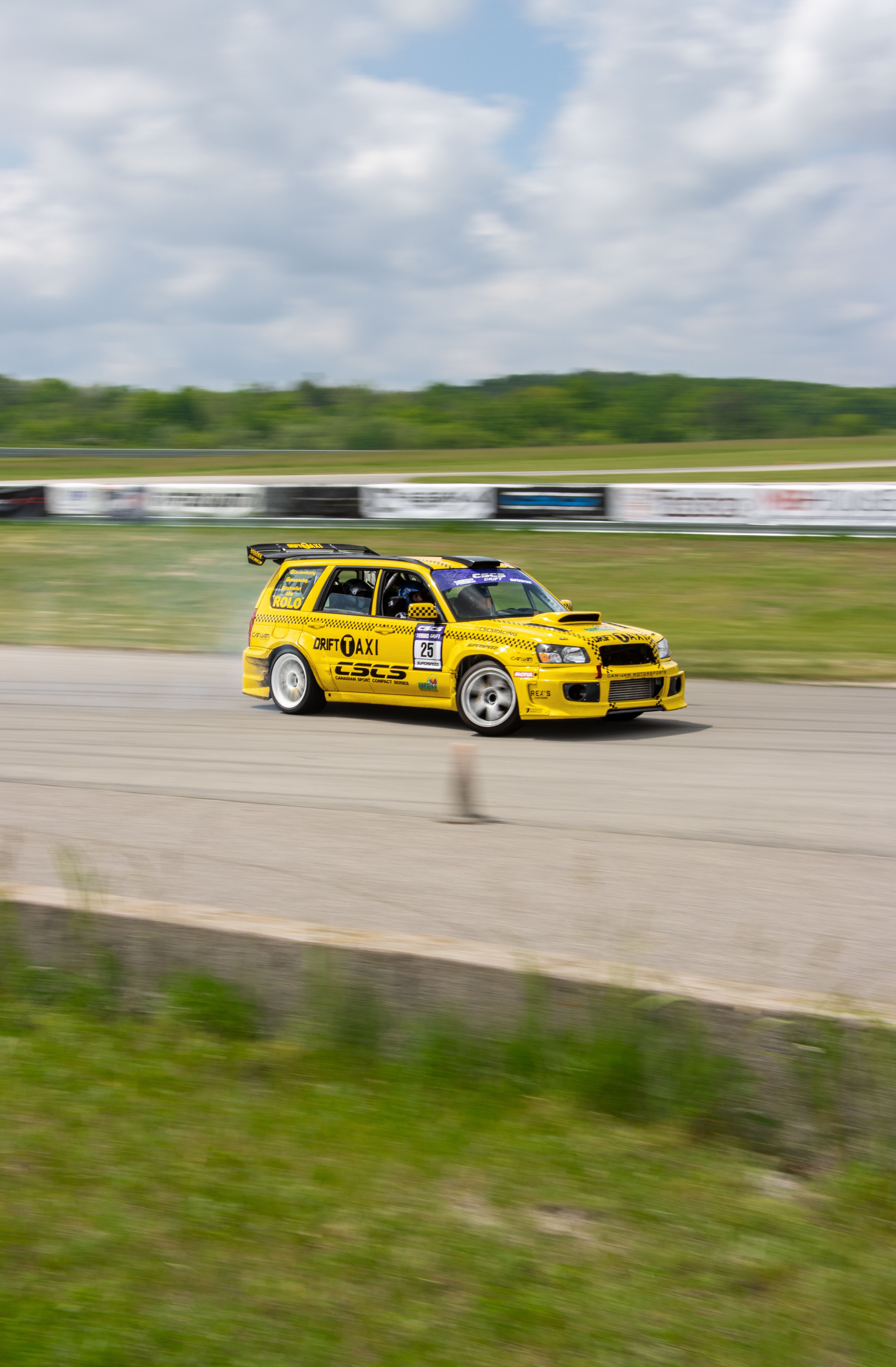 A yellow car is drifting on a track · Free Stock Photo