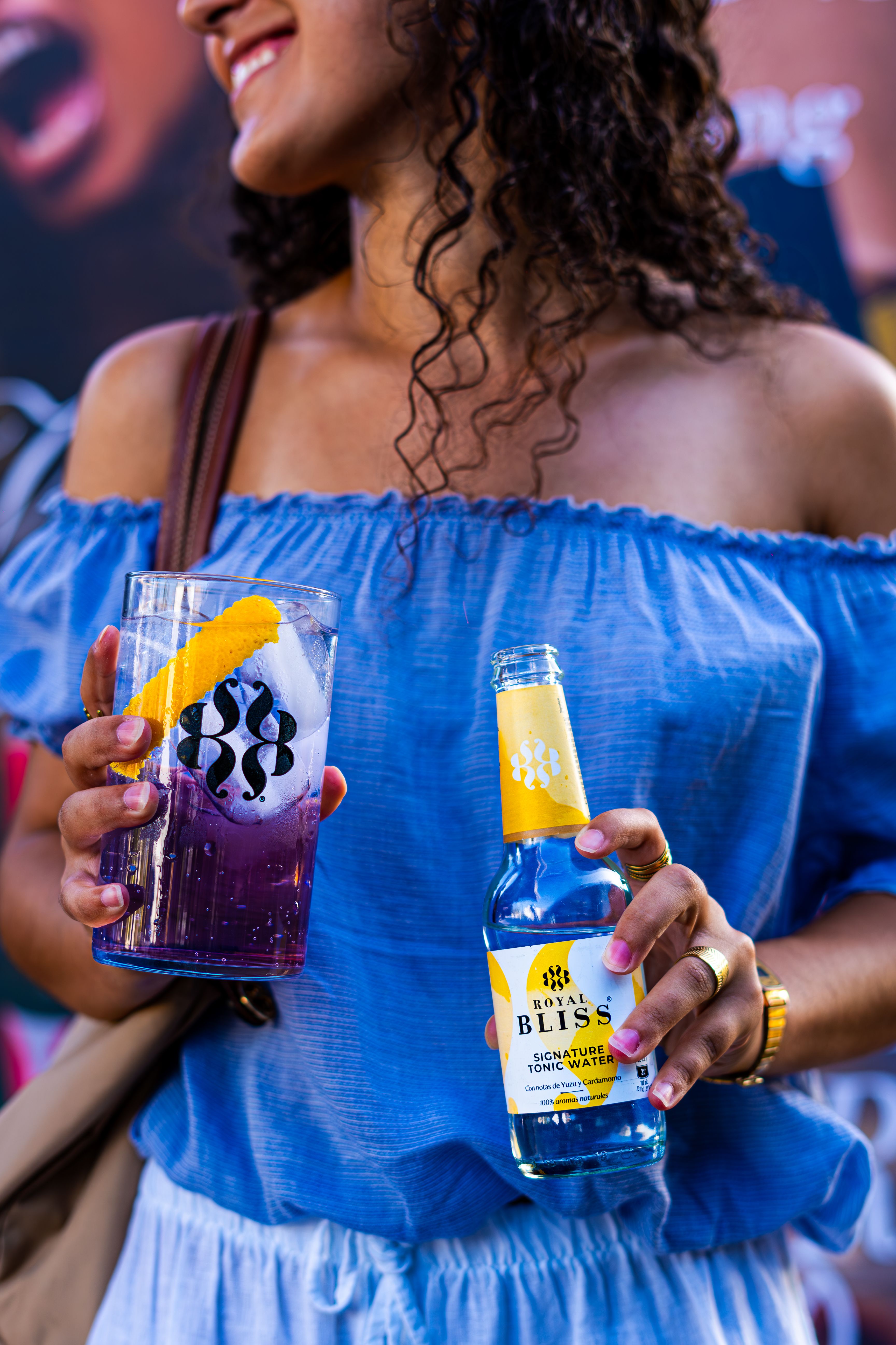 A woman holding a bottle of vodka and a drink · Free Stock Photo