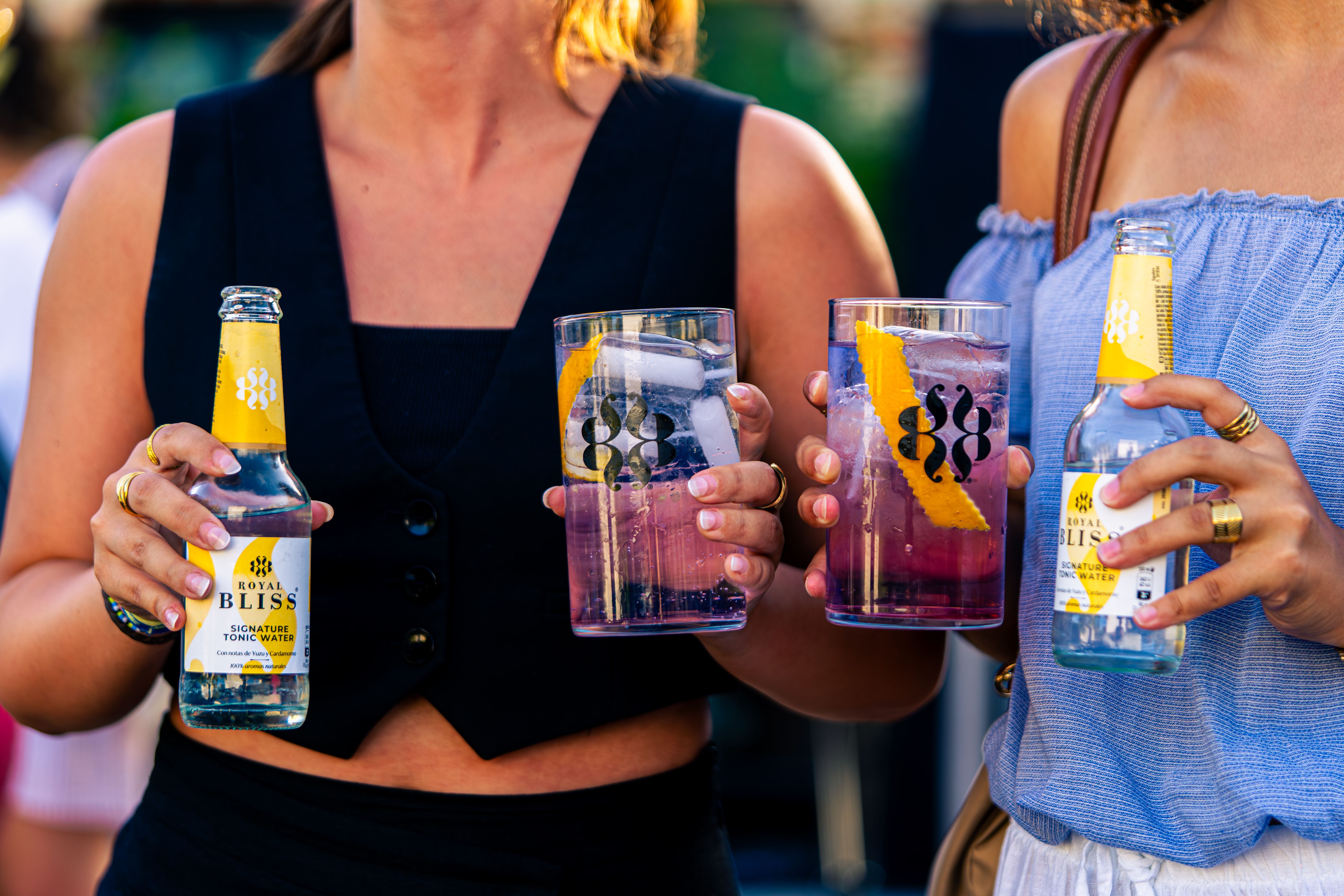 Two women holding up drinks with a bottle of vodka · Free Stock Photo
