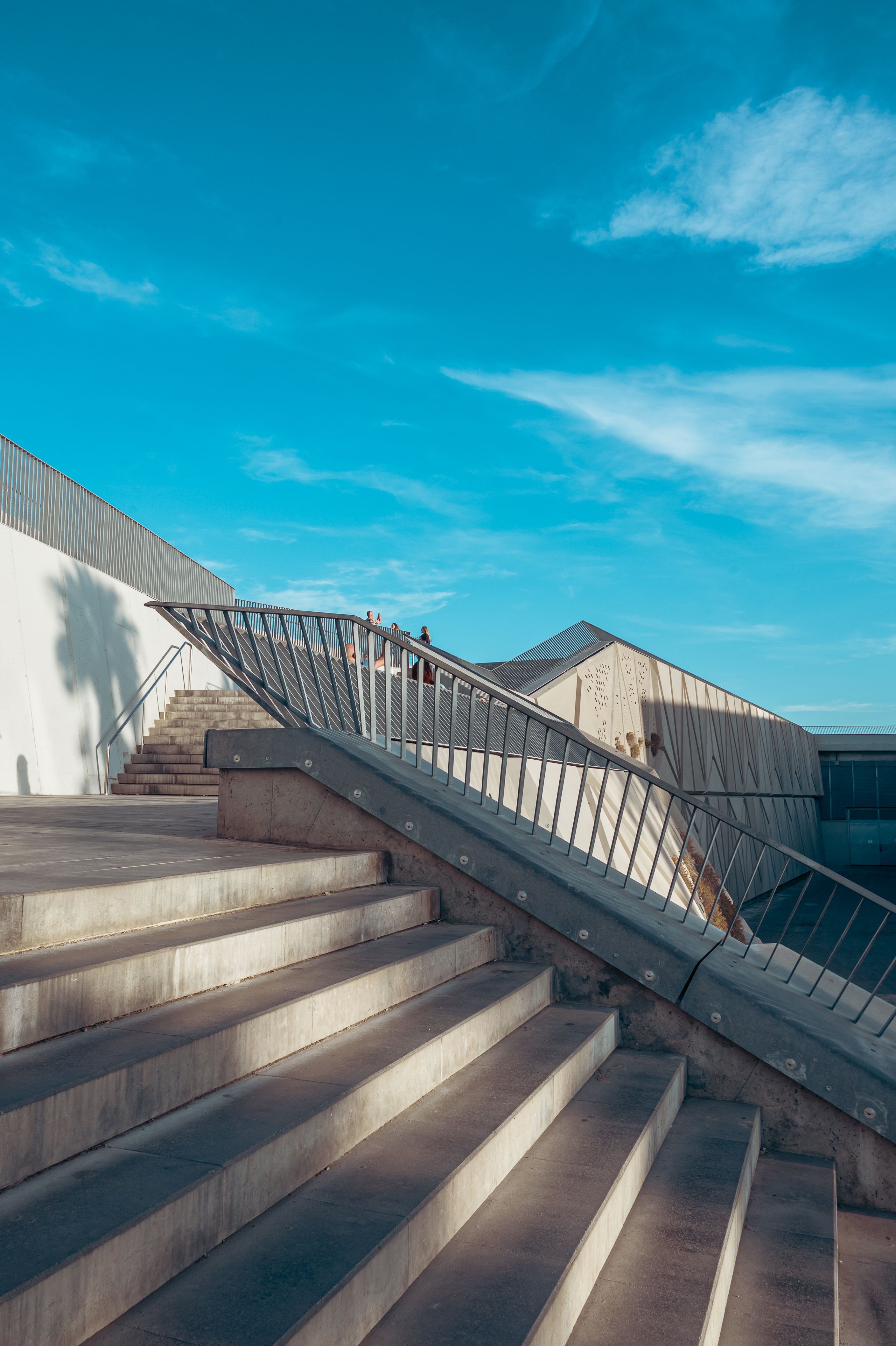 A staircase with a blue sky and a person walking up it · Free Stock Photo
