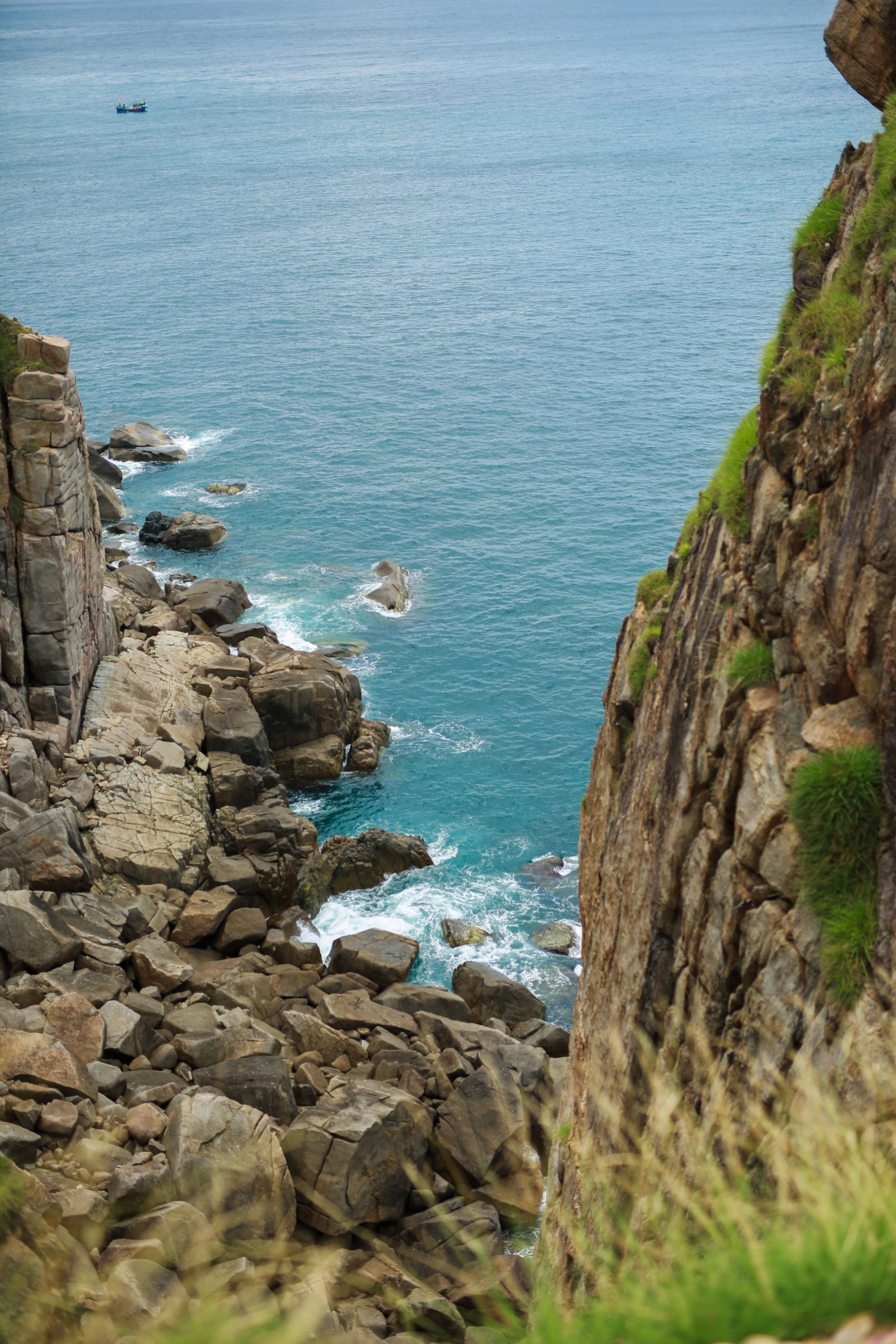 A rocky cliff with a view of the ocean · Free Stock Photo