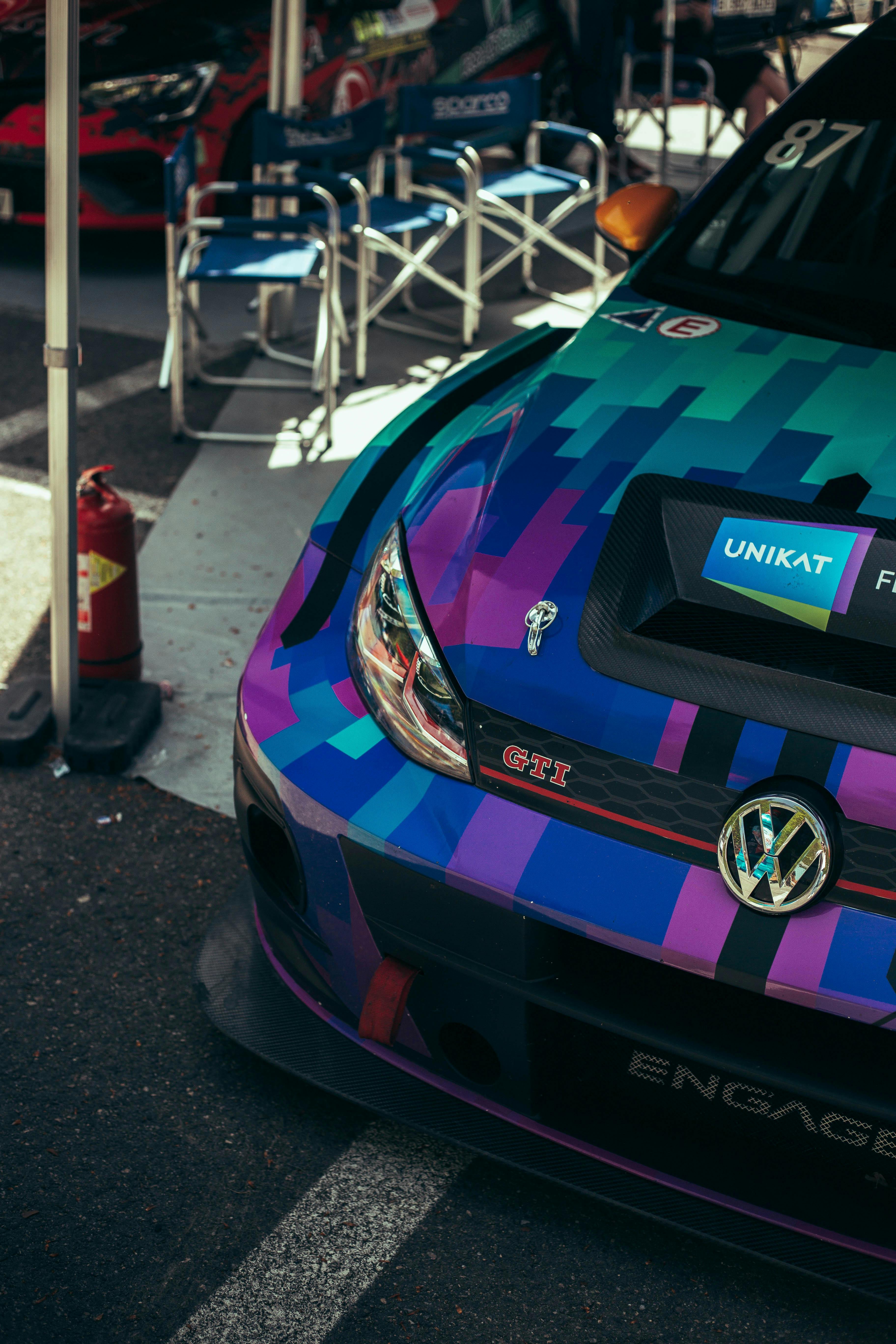 A car with a colorful paint job parked at a race track · Free Stock Photo
