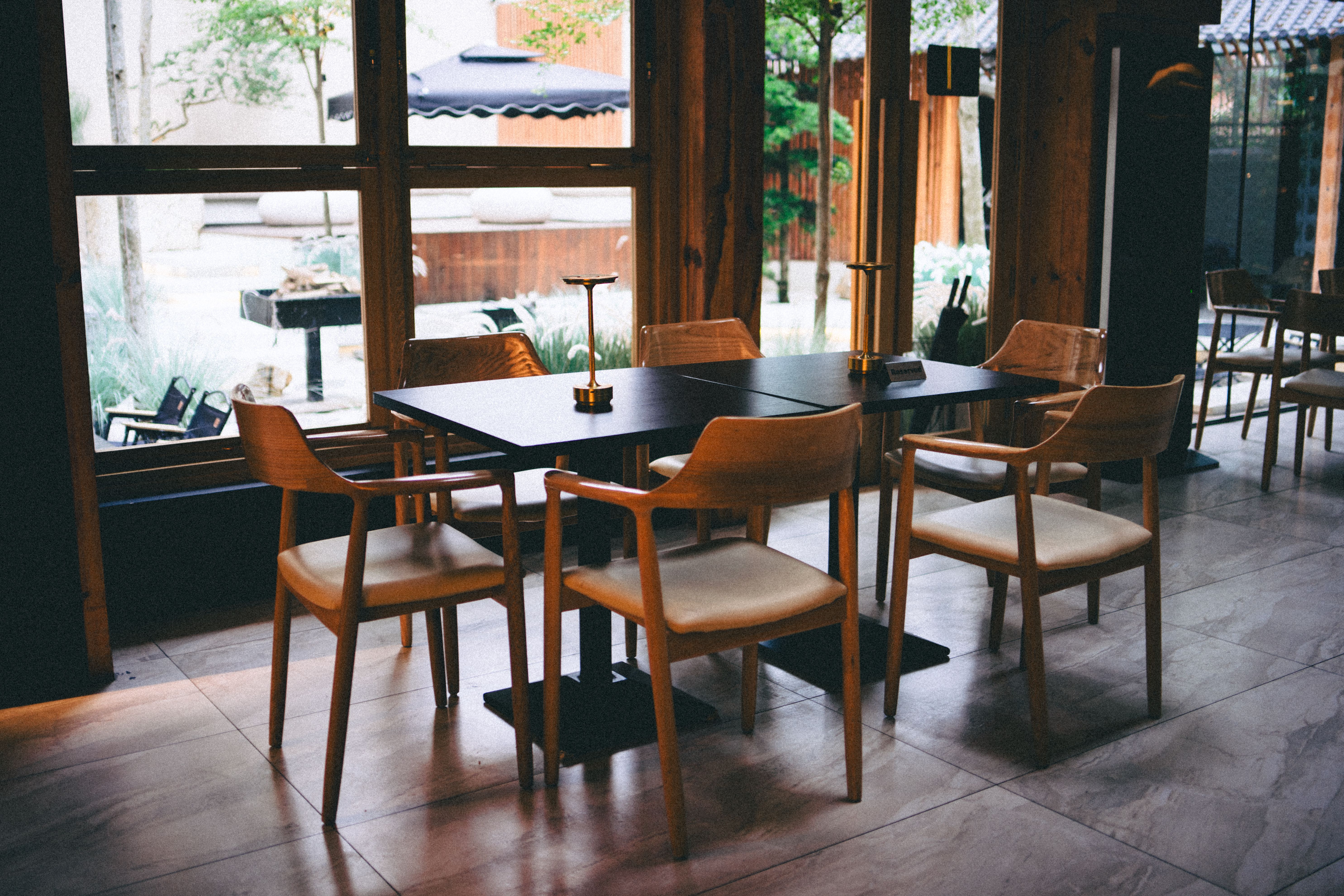 A restaurant with wooden tables and chairs · Free Stock Photo