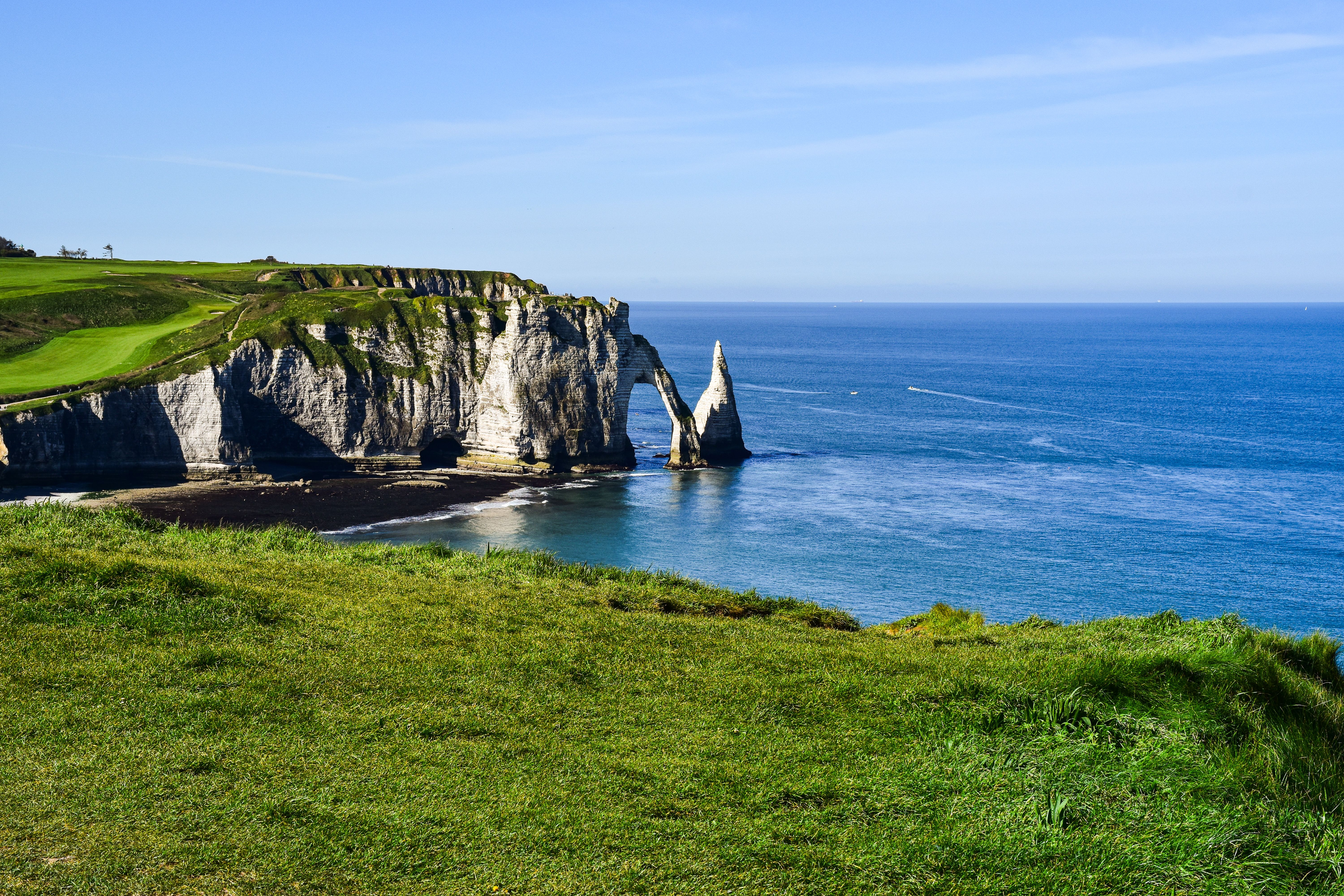 A grassy hill with a cliff and ocean in the background · Free Stock Photo