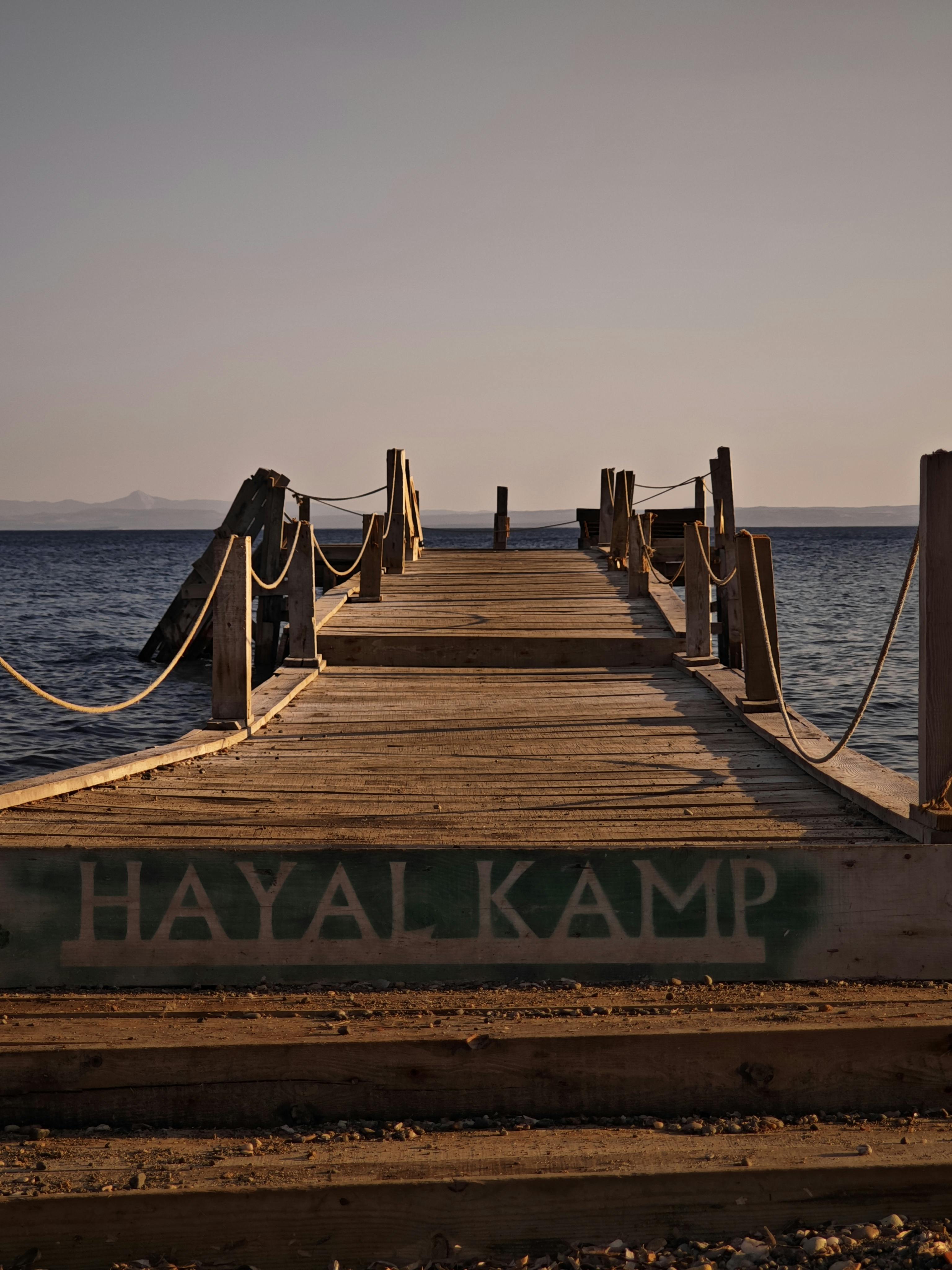 A wooden pier with the word hakal kamp on it · Free Stock Photo