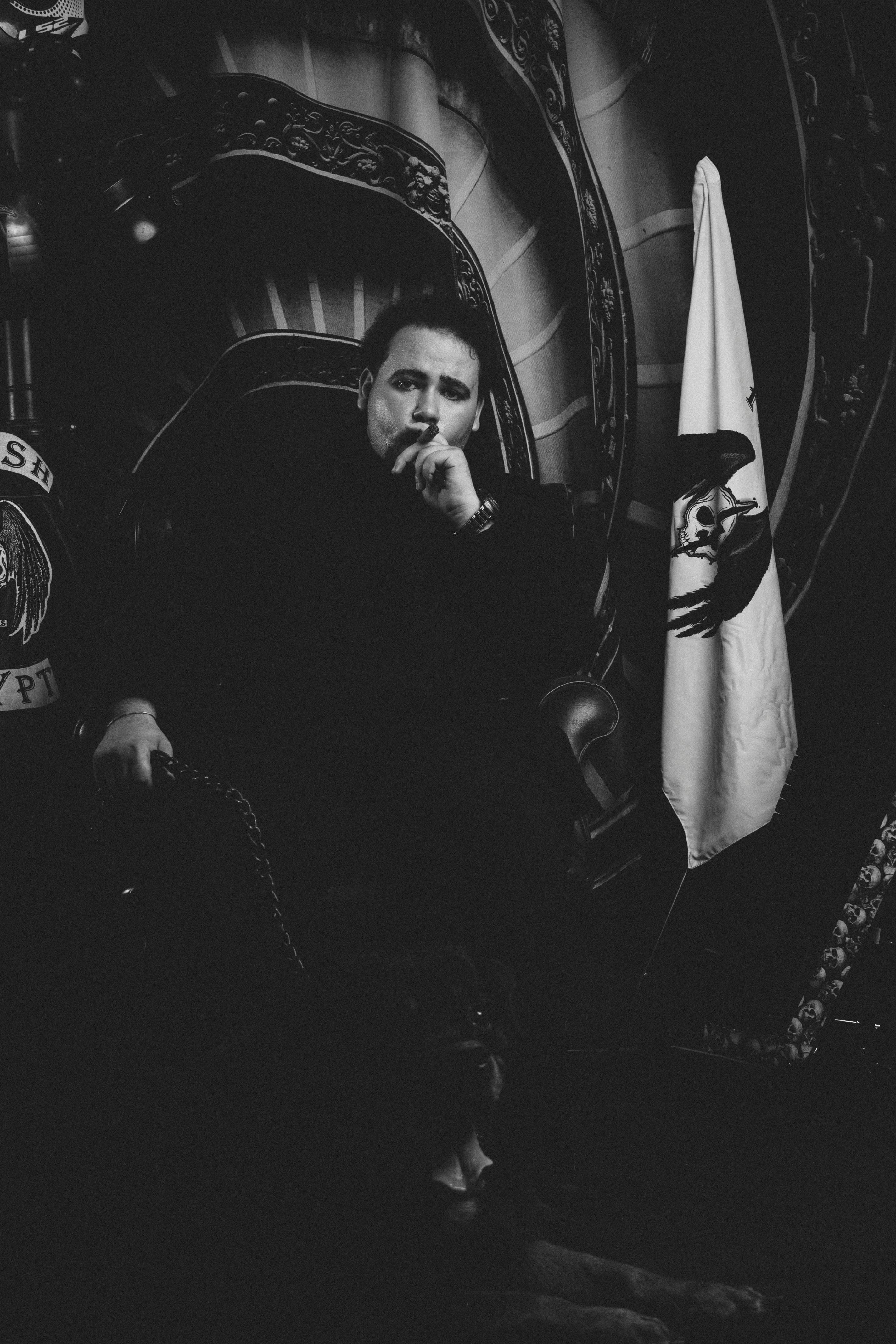 A man sitting in a chair with a flag behind him · Free Stock Photo