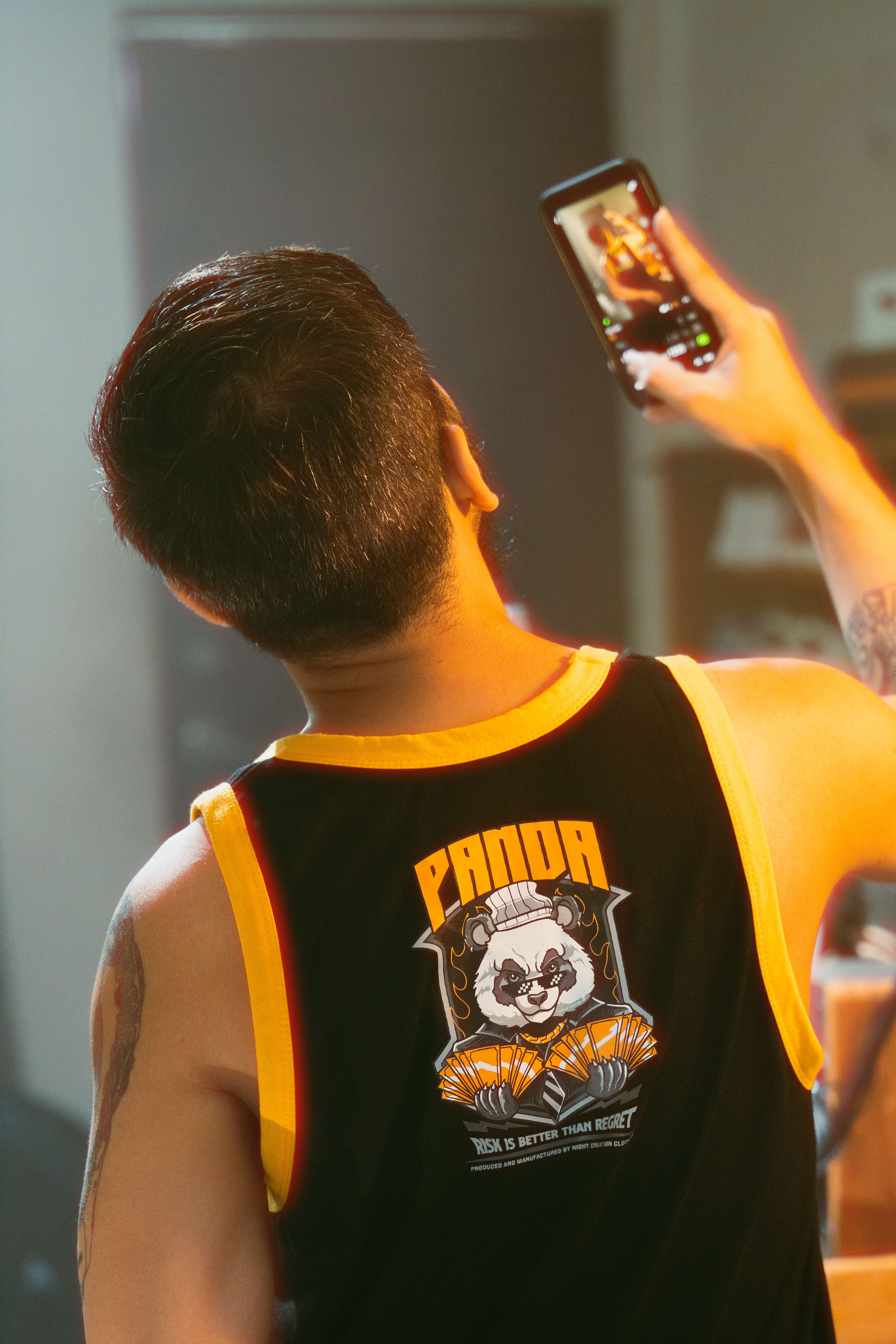 Free Man taking a selfie wearing a panda-themed tank top, capturing a ...