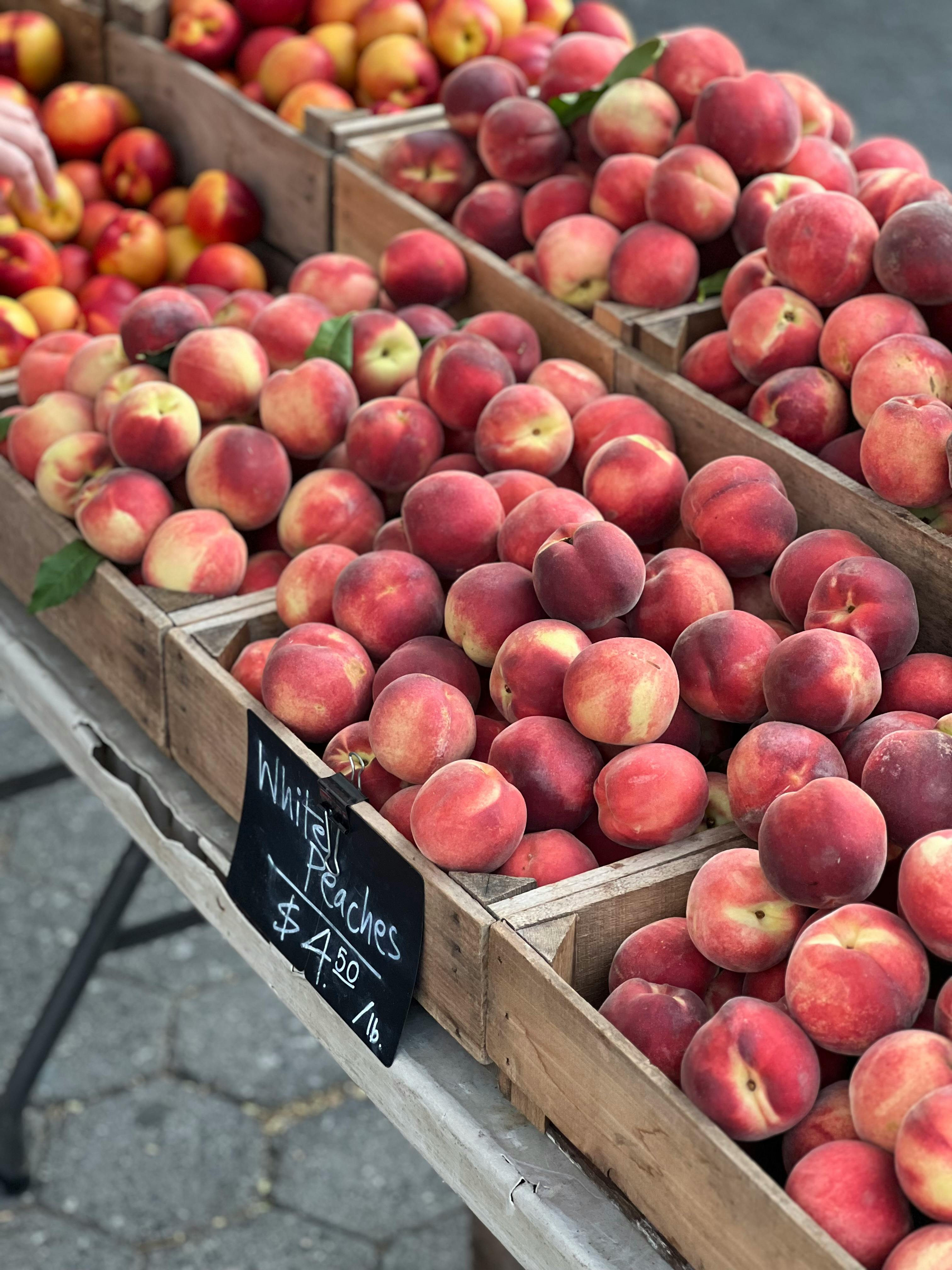 Peaches are displayed in wooden crates at a farmers market · Free Stock ...