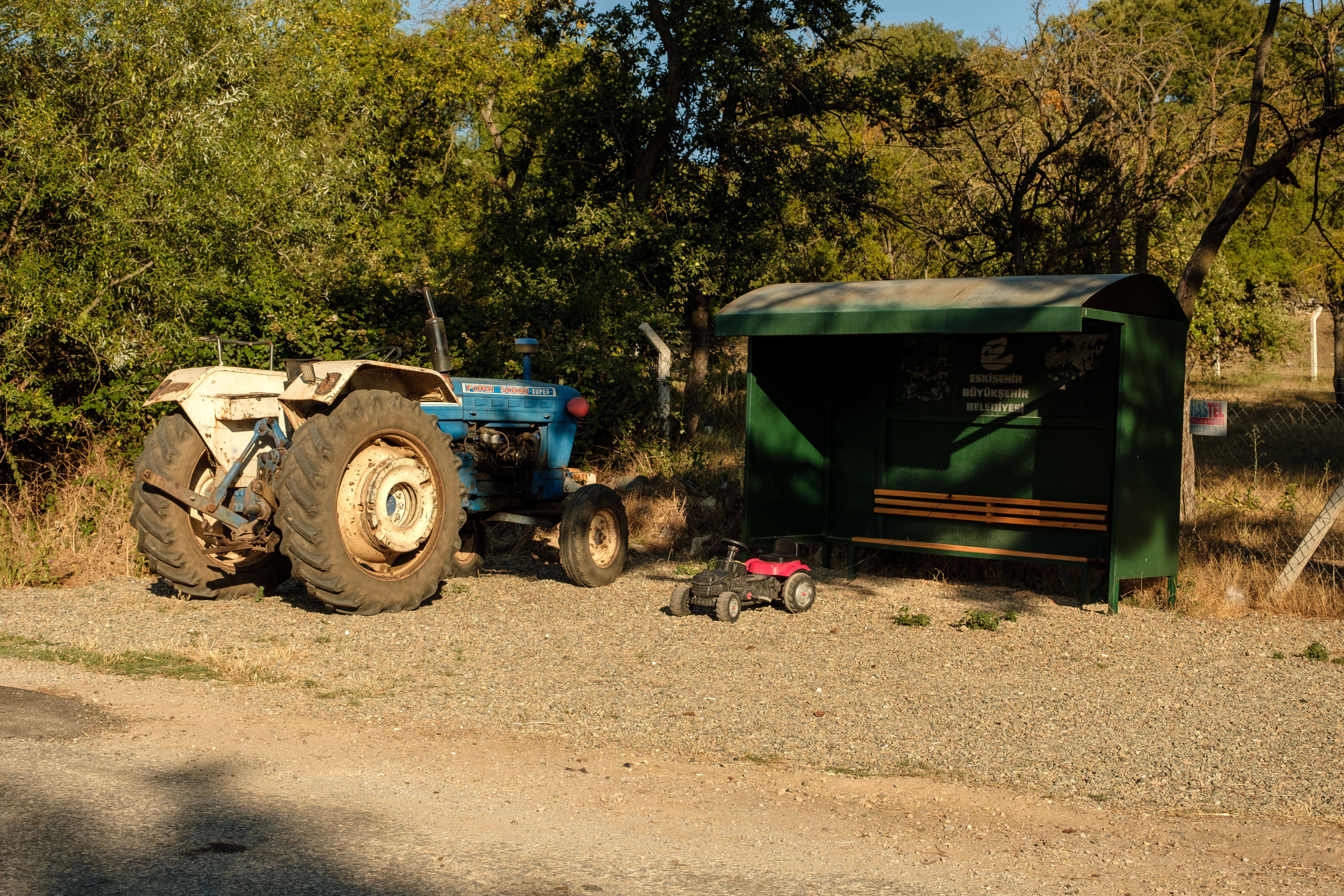 A tractor parked next to a small building · Free Stock Photo