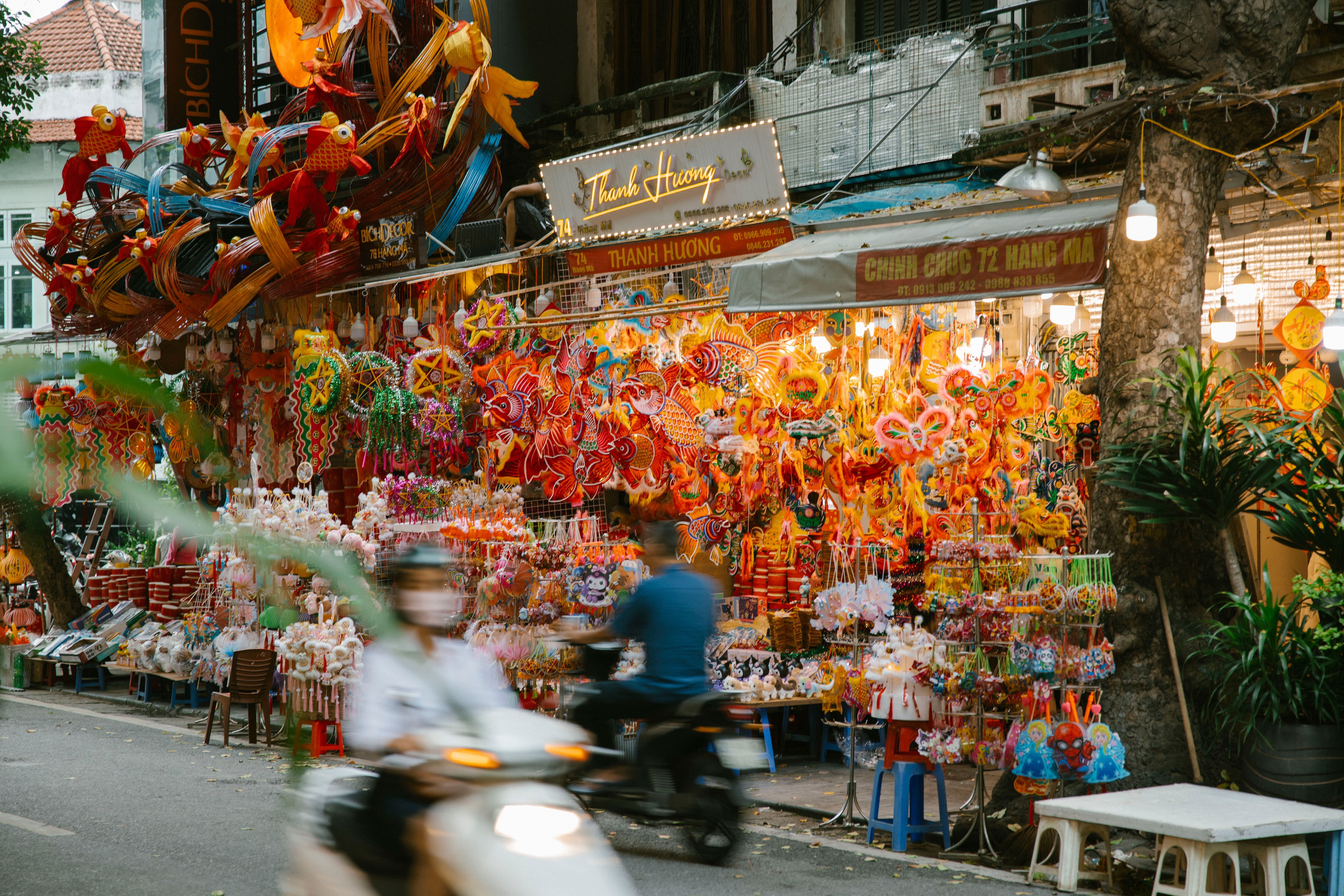 A street with many colorful shops and people on motorcycles · Free ...