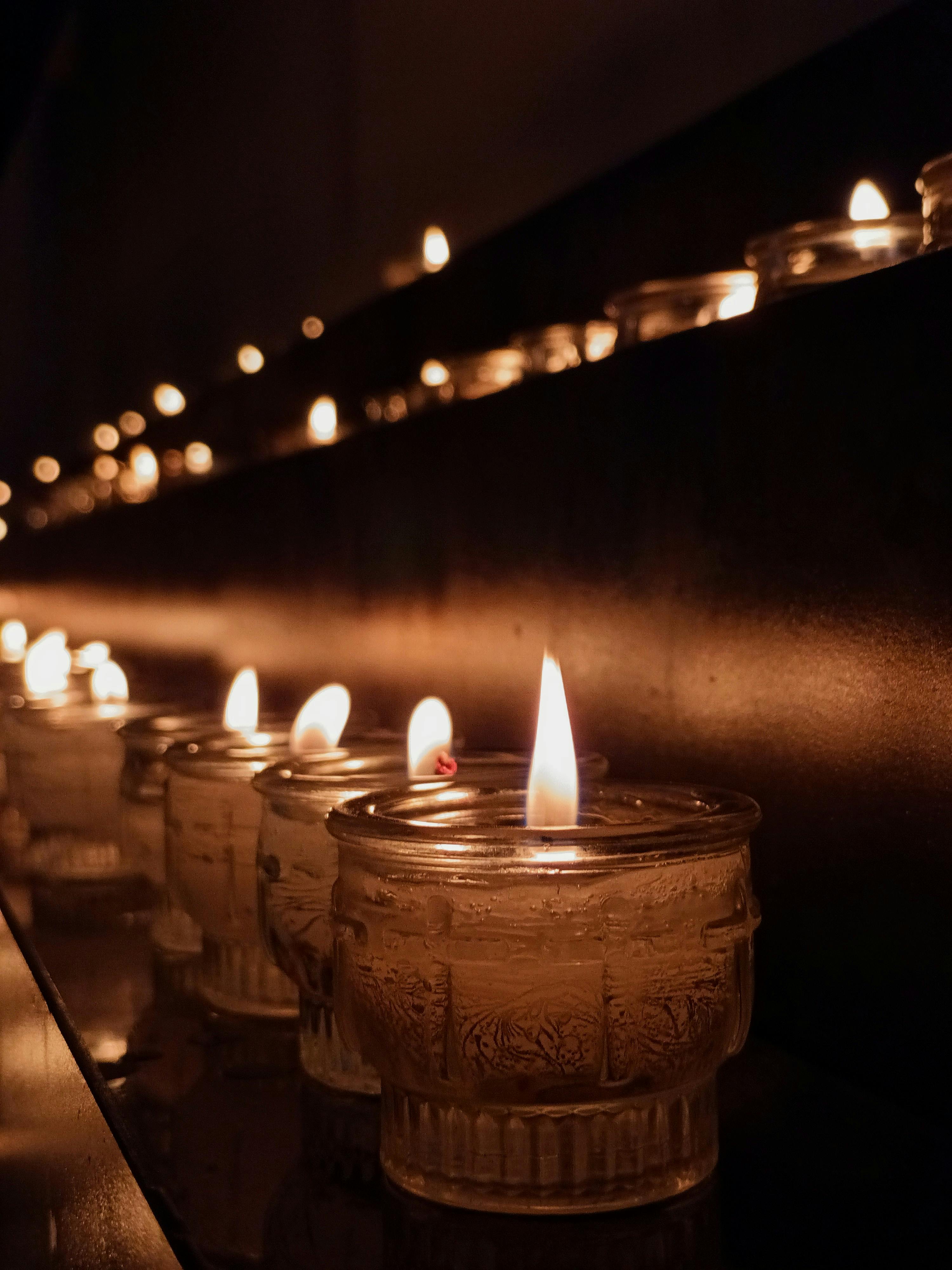 Candles lit in a row in a dark room · Free Stock Photo