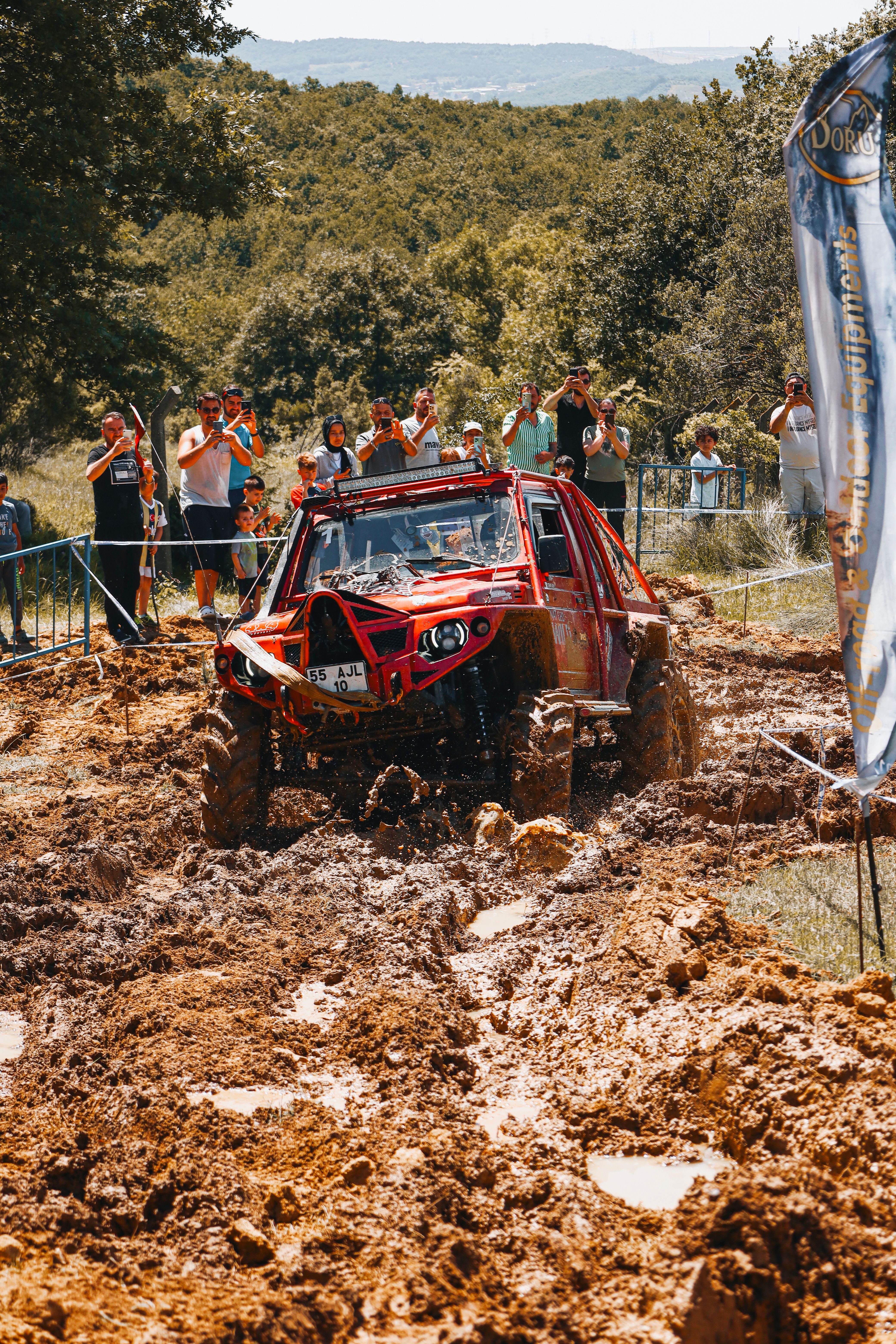 A red off - road vehicle is driving through mud · Free Stock Photo