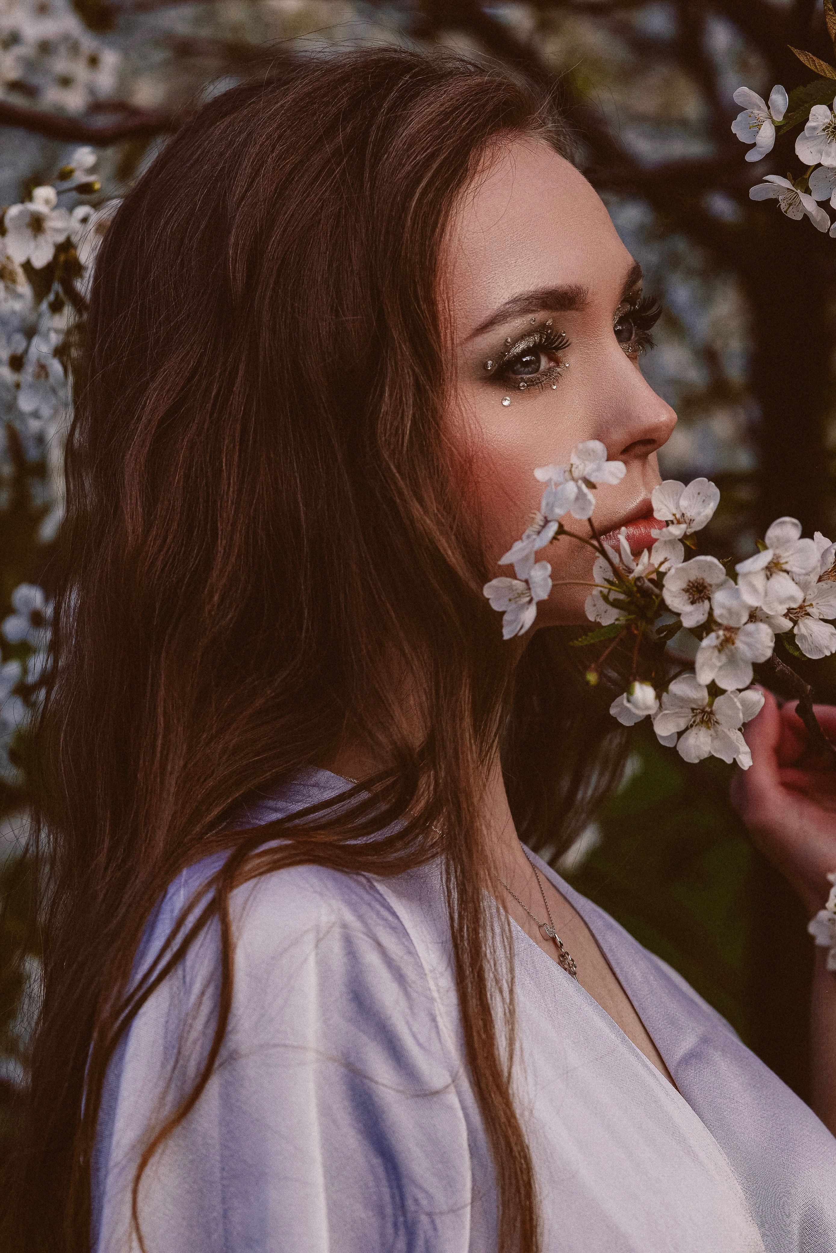 Close-up Photo of Woman's Face Behind White Flowers · Free Stock Photo