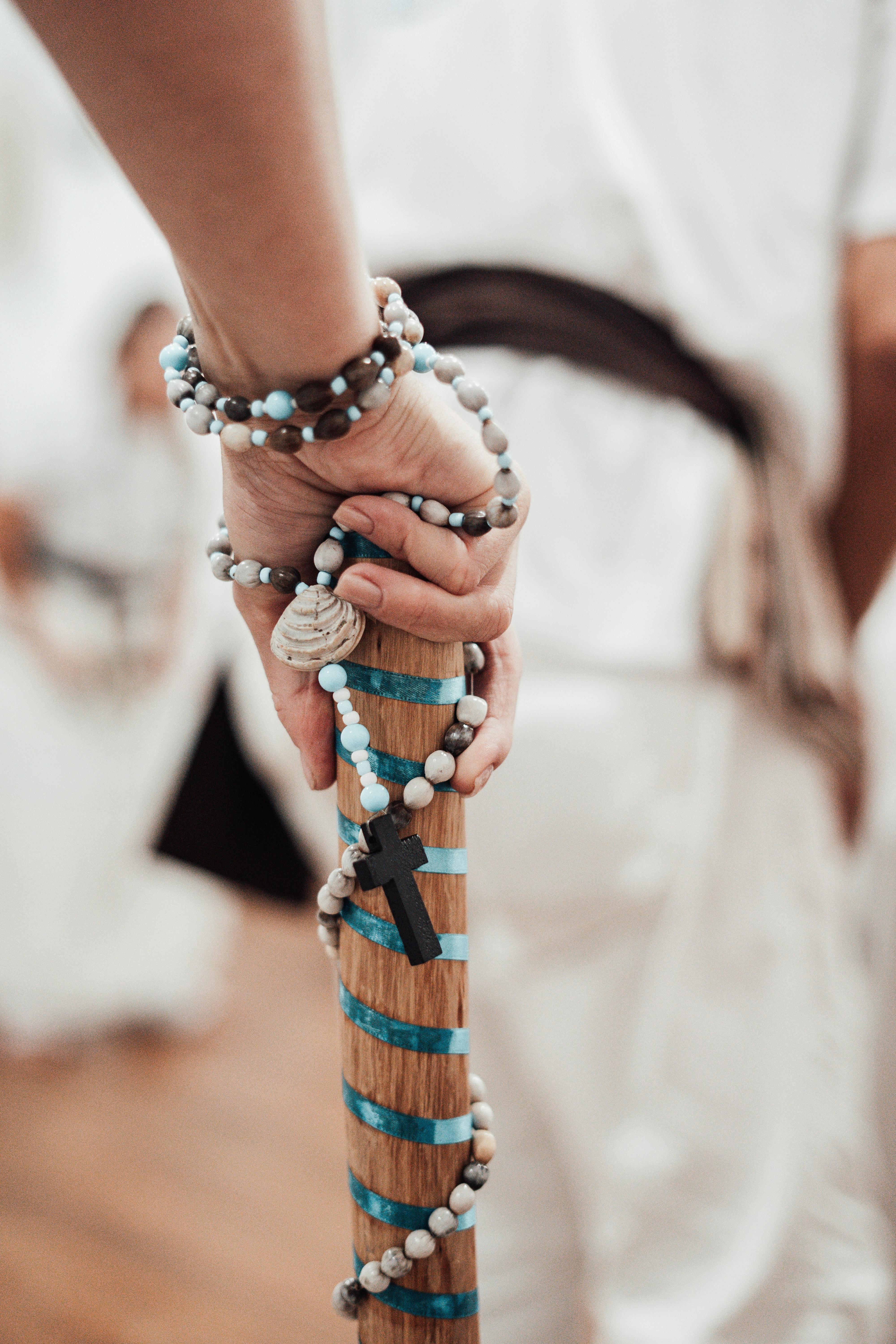 A person holding a wooden stick with beads on it · Free Stock Photo