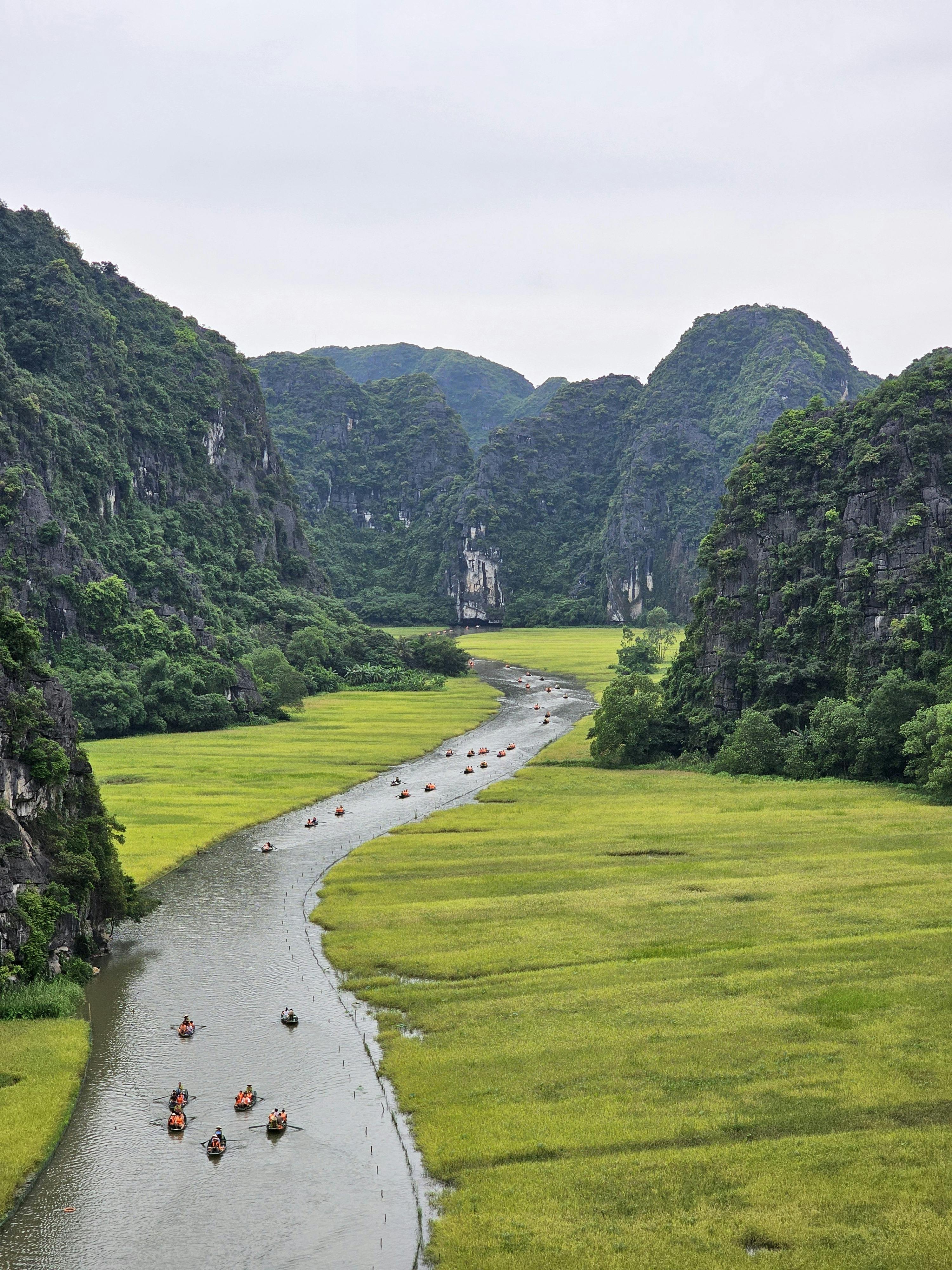 A river runs through a lush green valley · Free Stock Photo