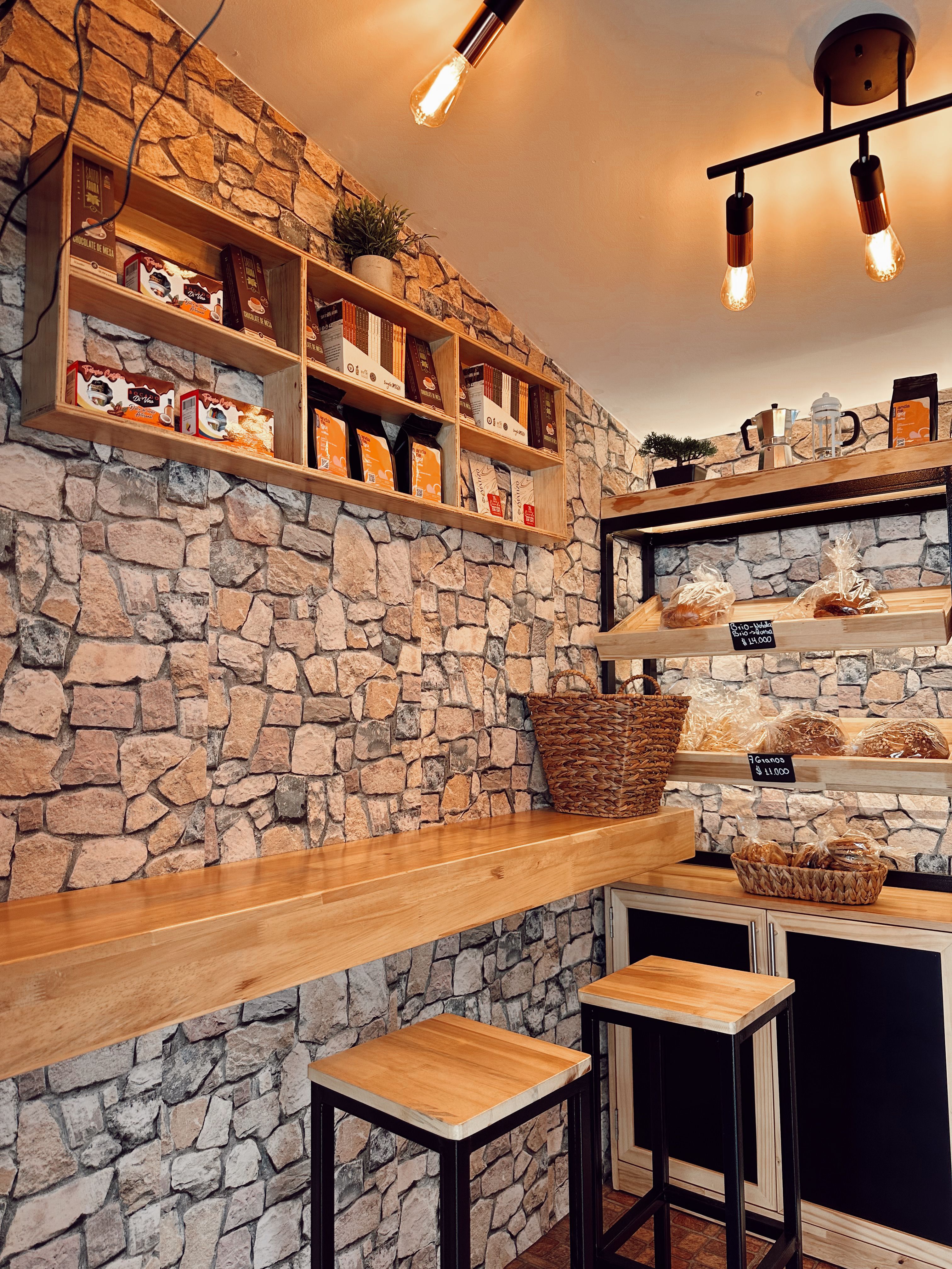A stone walled kitchen with wooden stools · Free Stock Photo