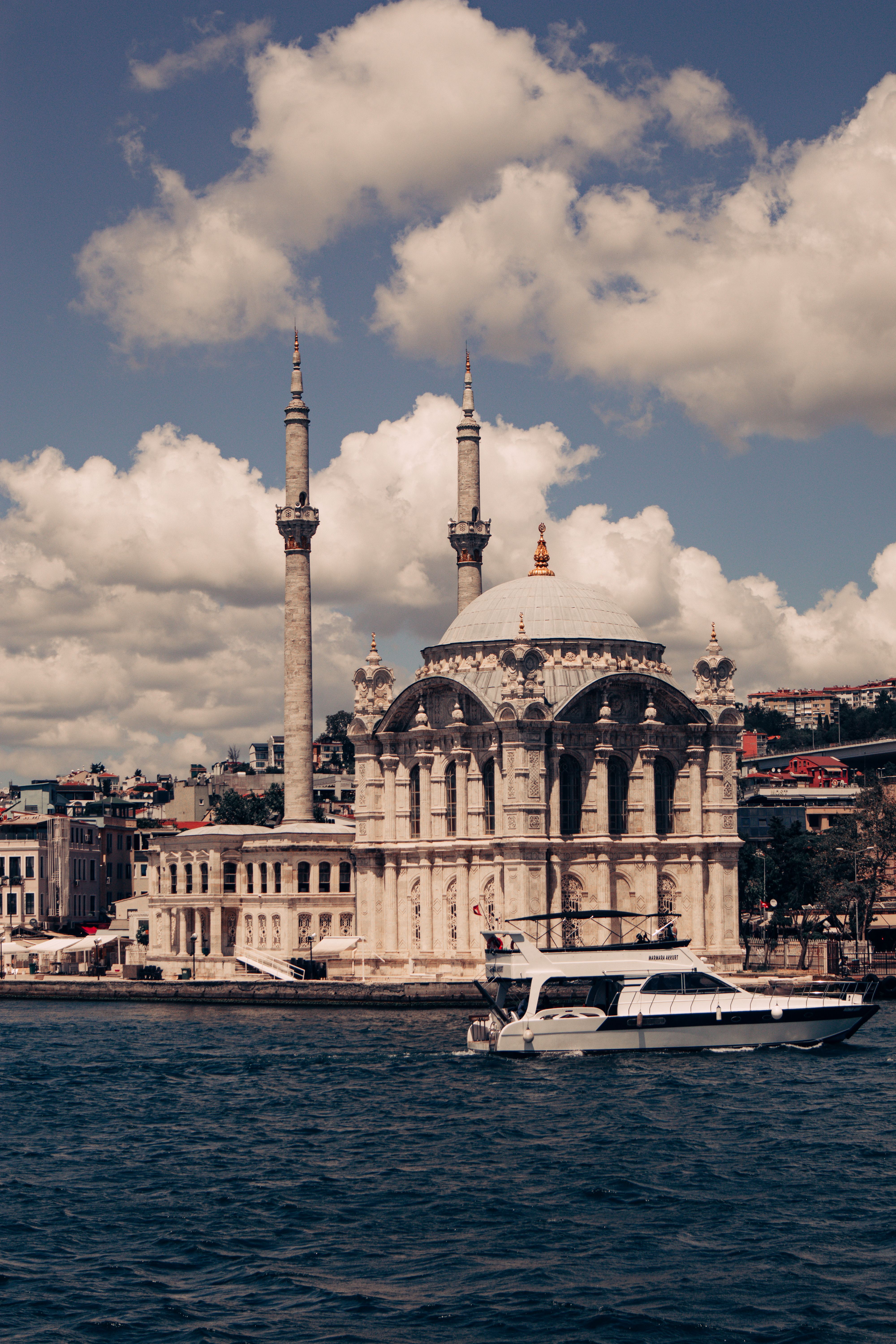 A boat is sailing by a mosque in the water · Free Stock Photo