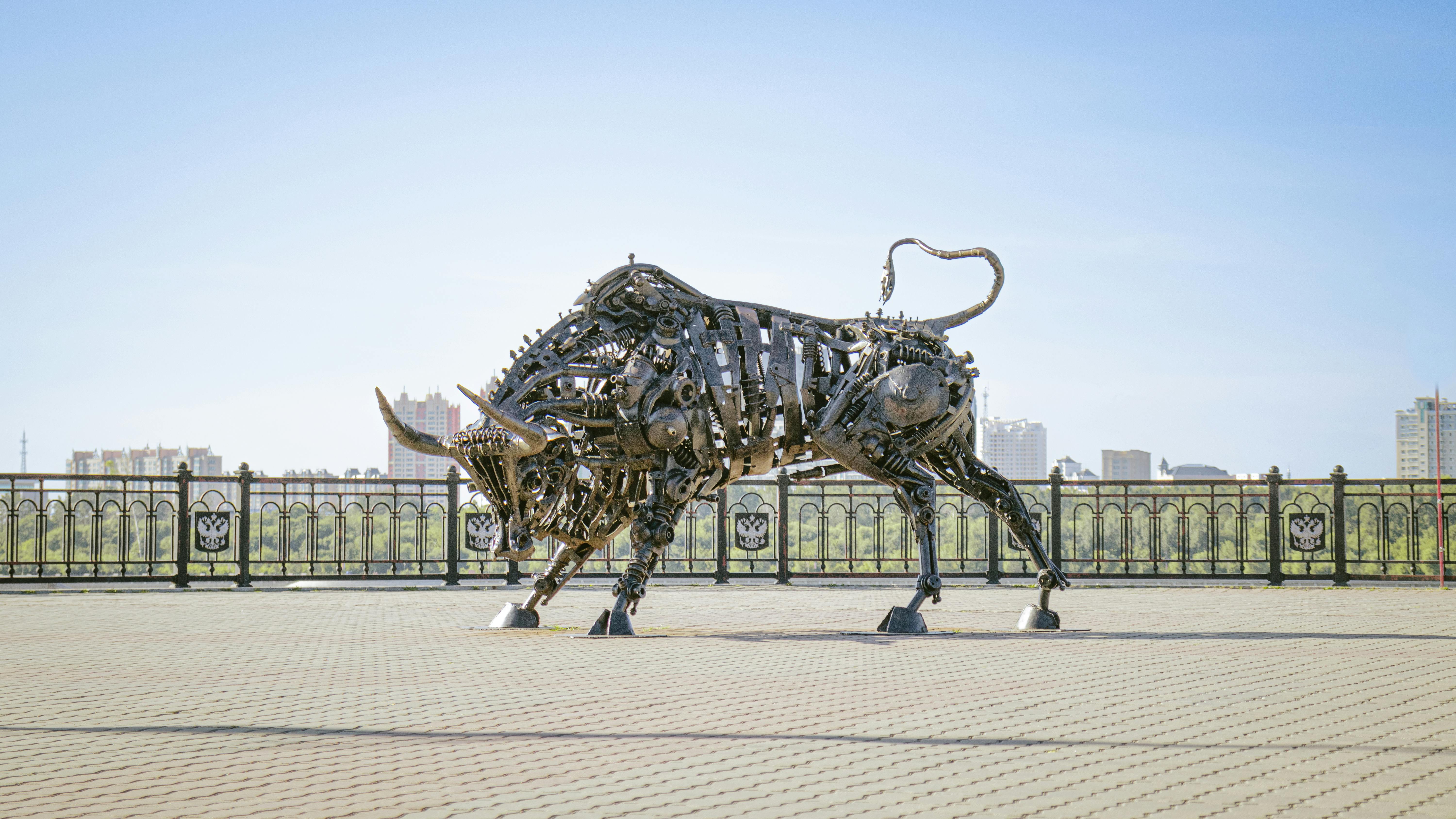 A large metal bull statue in the middle of a park · Free Stock Photo