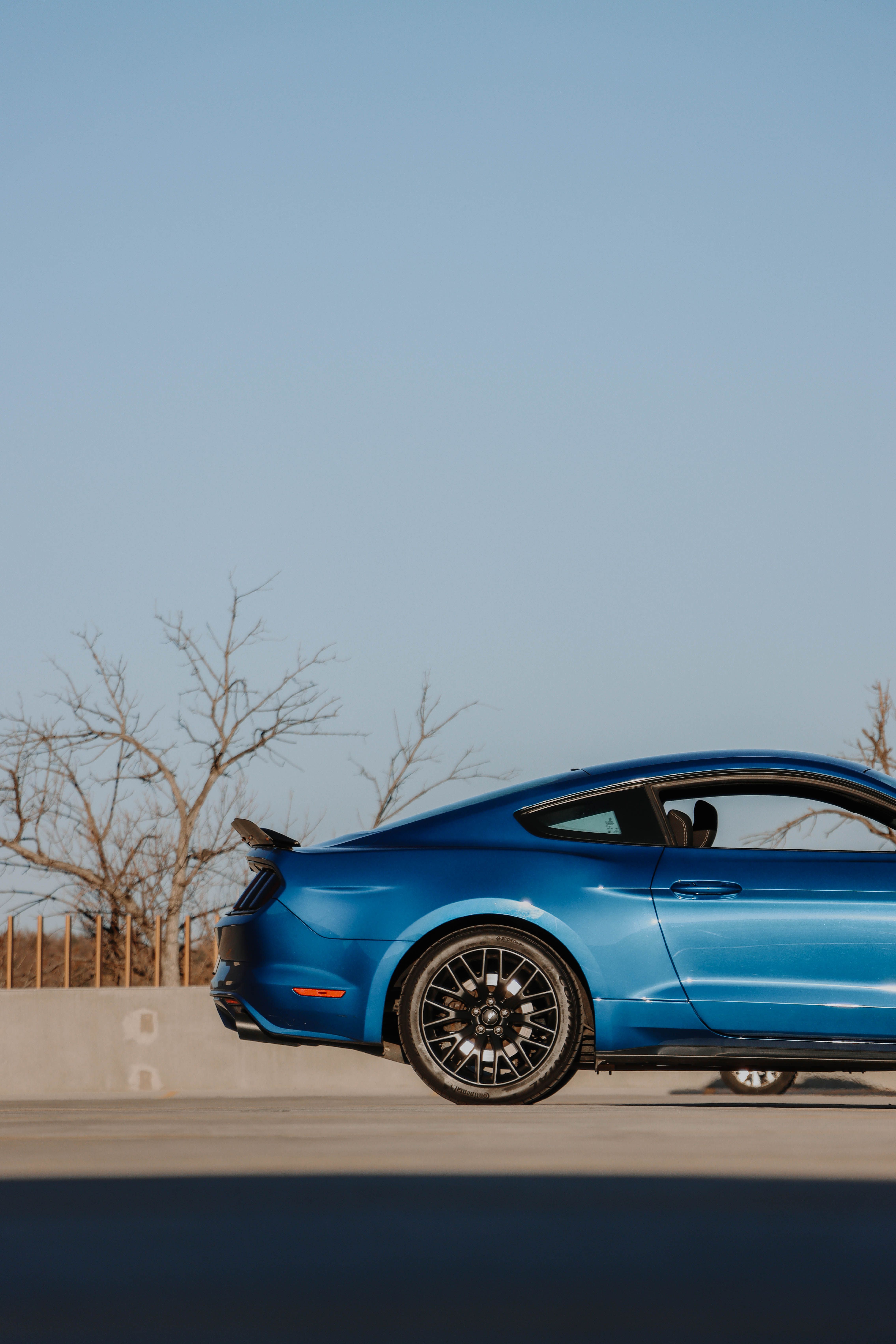 The blue mustang is parked on the street · Free Stock Photo