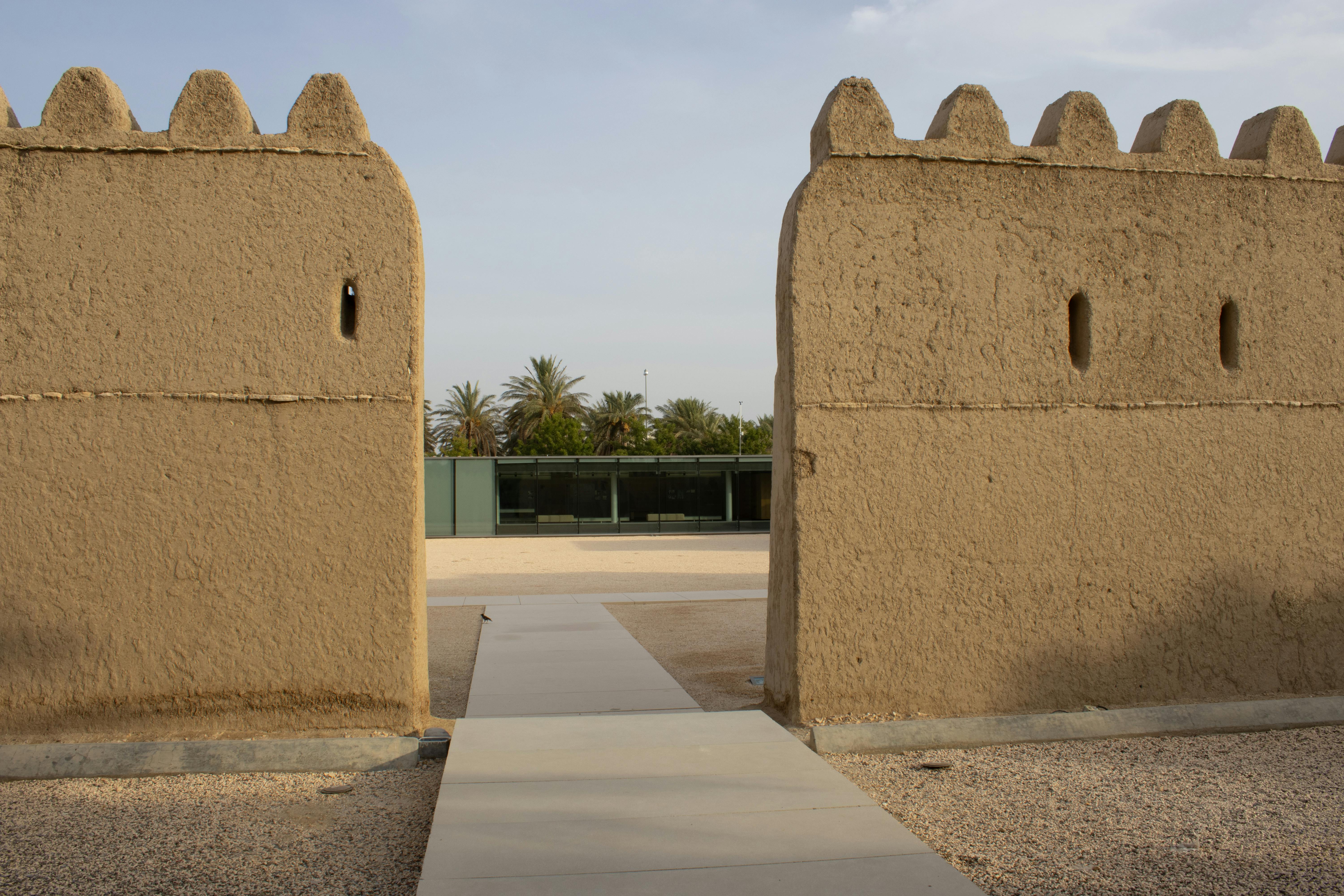 The entrance to a desert compound with two stone walls · Free Stock Photo