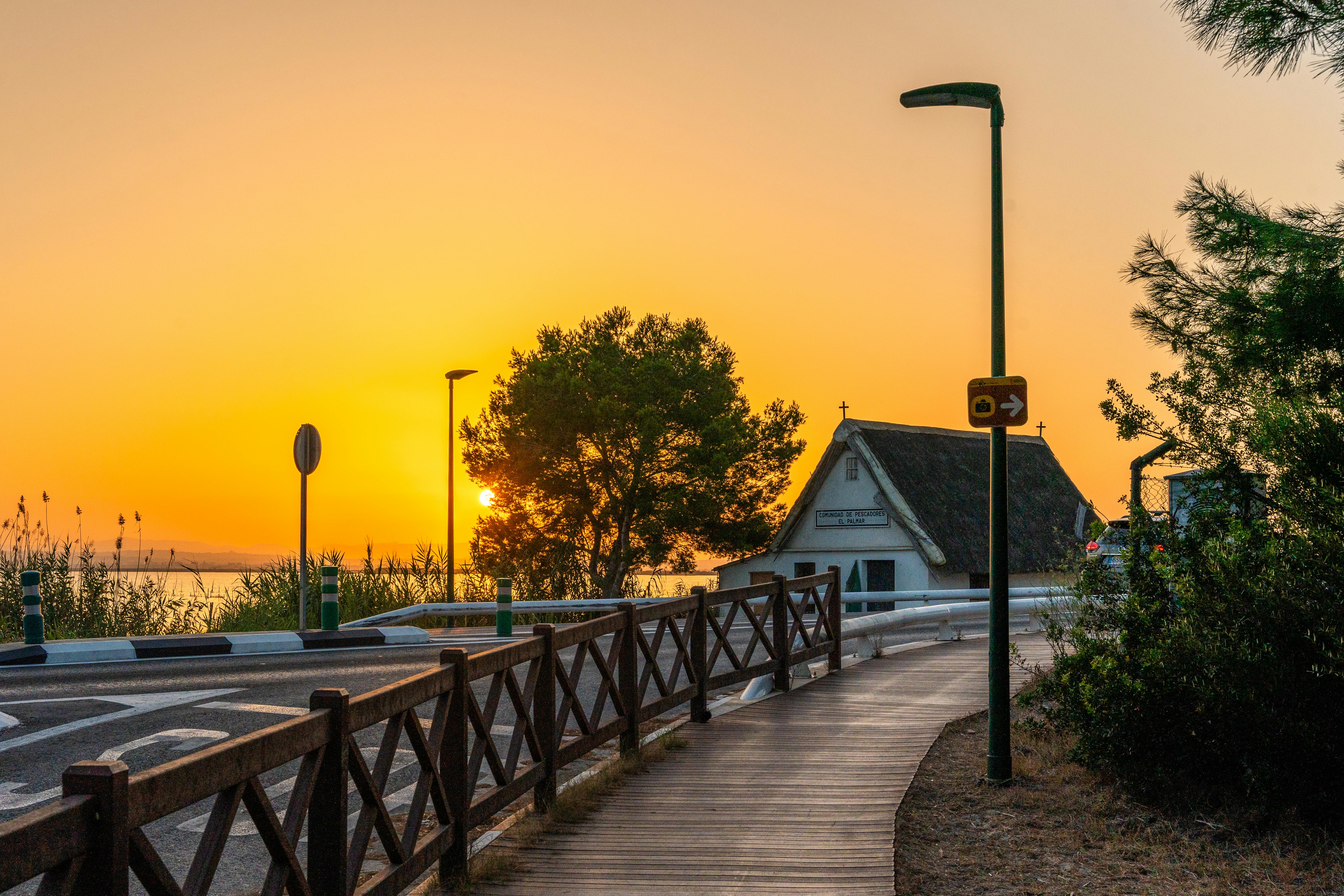 A sunset over a road with a walkway · Free Stock Photo