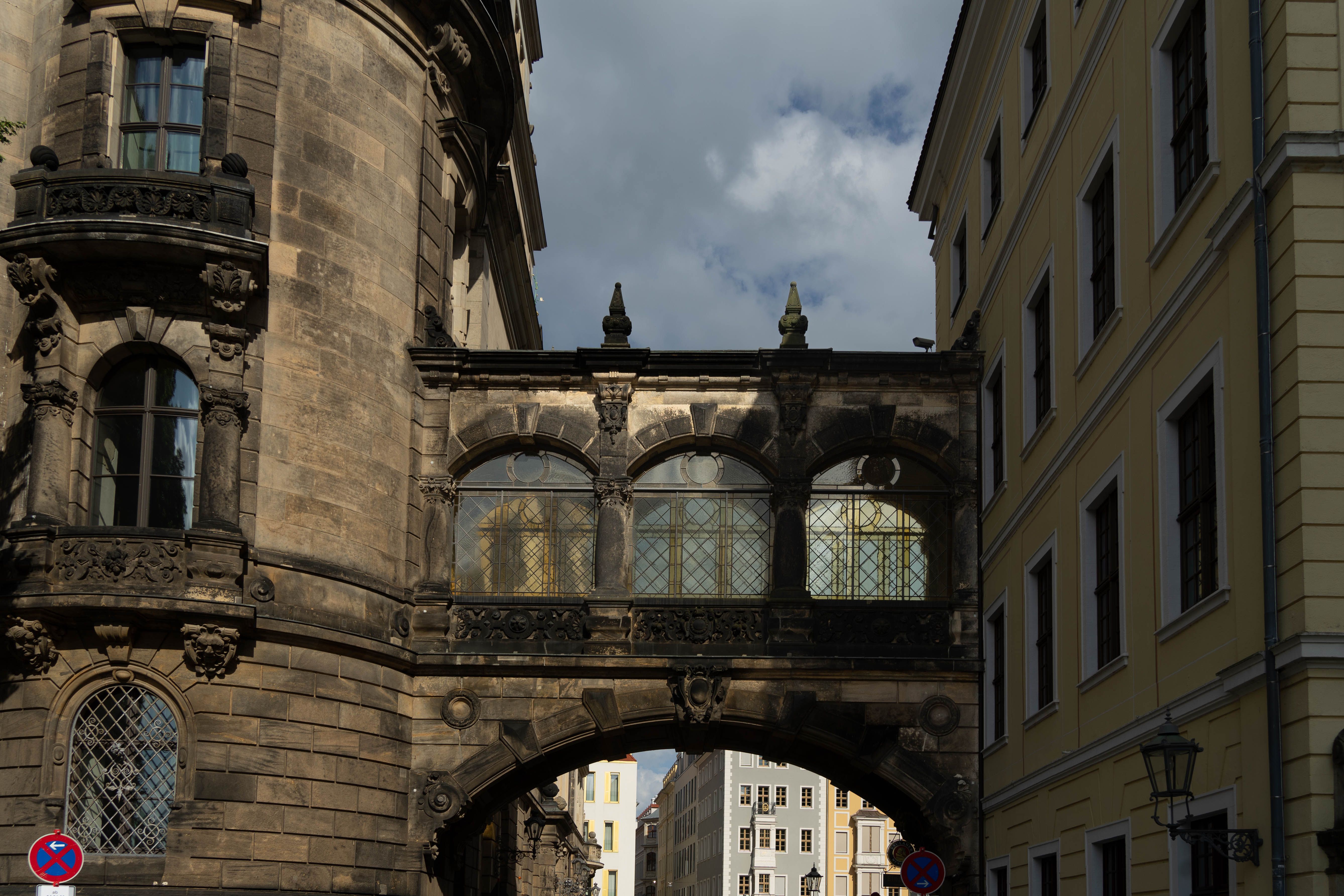 A bridge over a street with buildings on both sides · Free Stock Photo