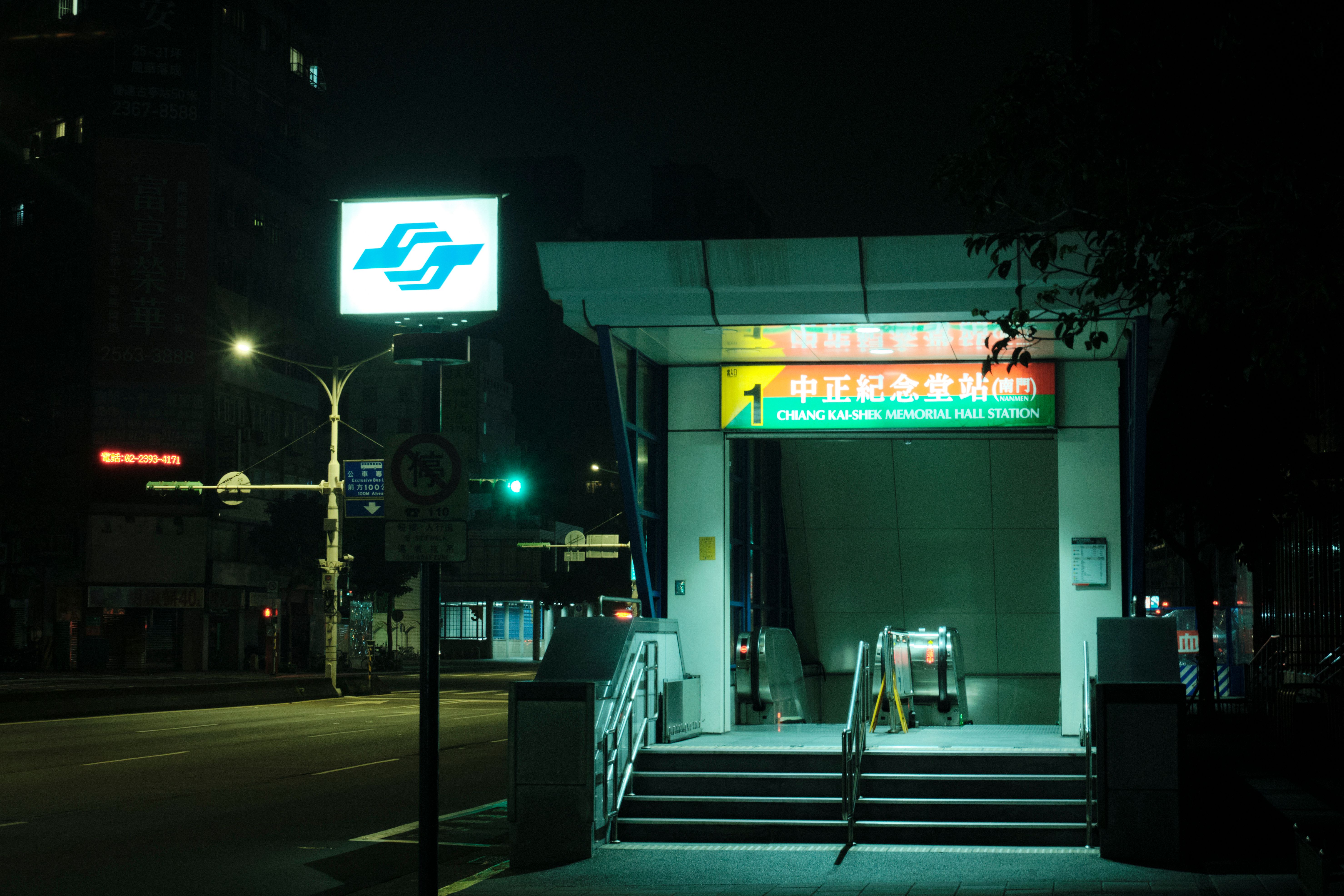 A bus stop at night with a neon sign · Free Stock Photo