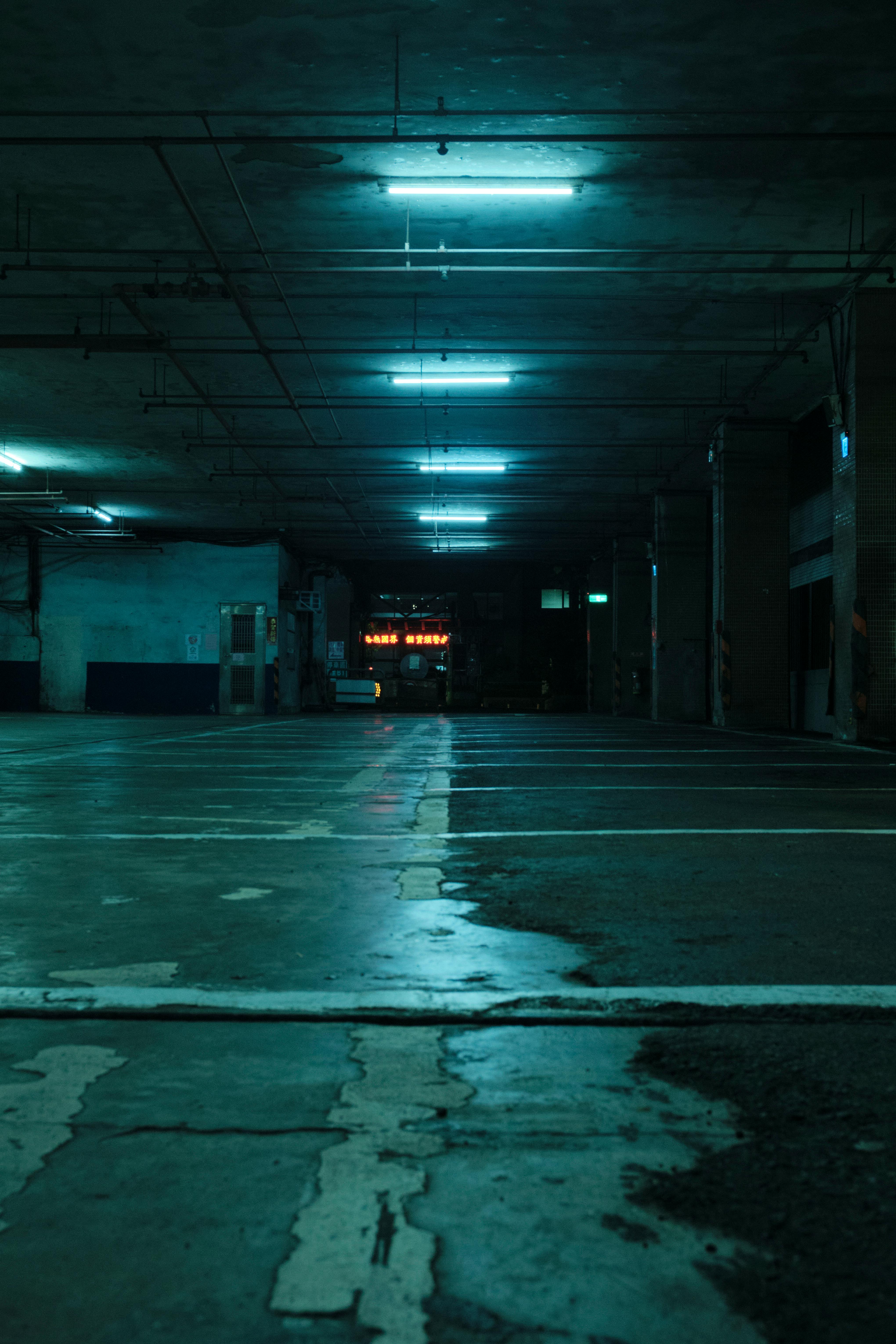 A dark empty parking garage with blue lights · Free Stock Photo