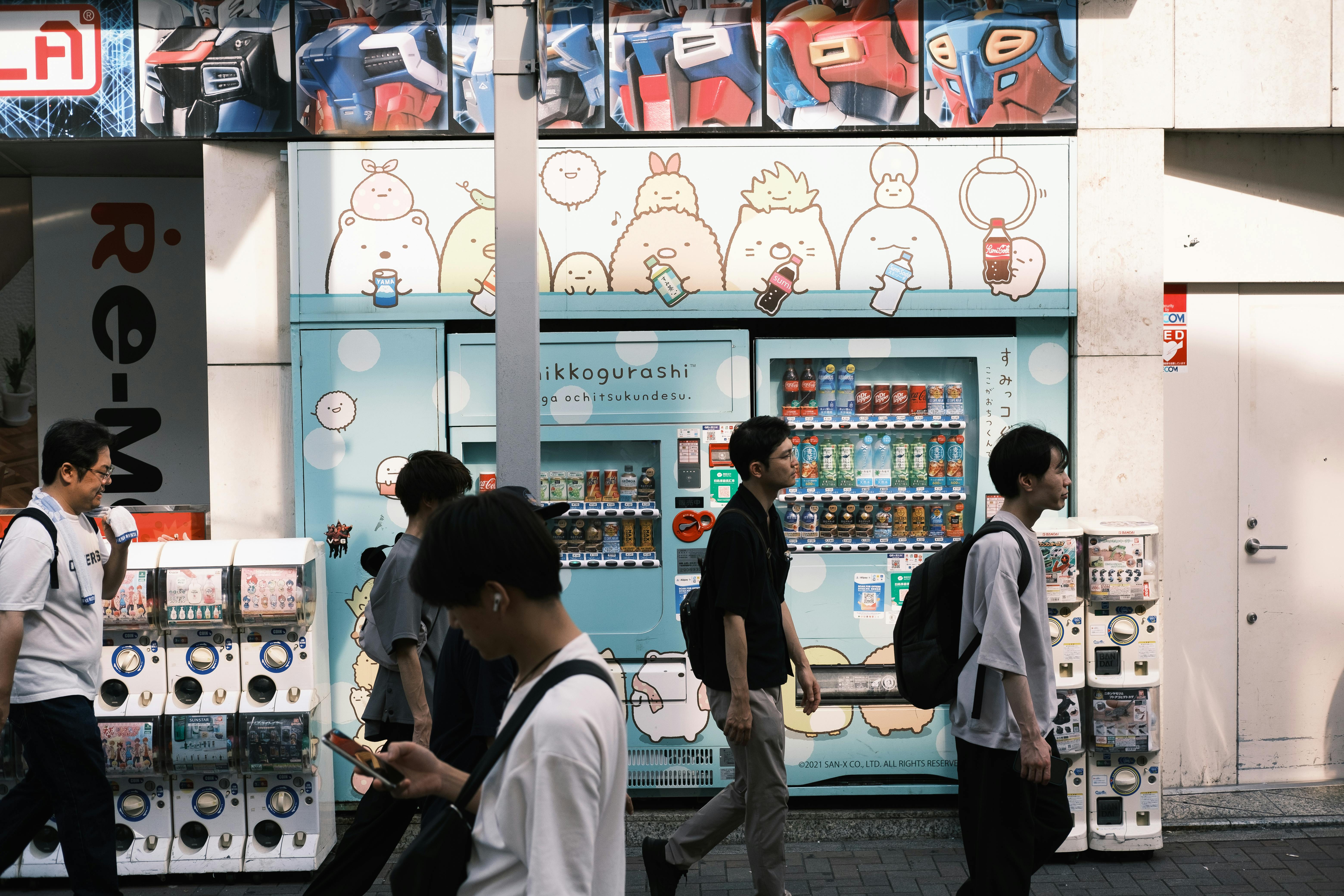 Man Walking Past Vending Machines in Tokyo Street · Free Stock Photo