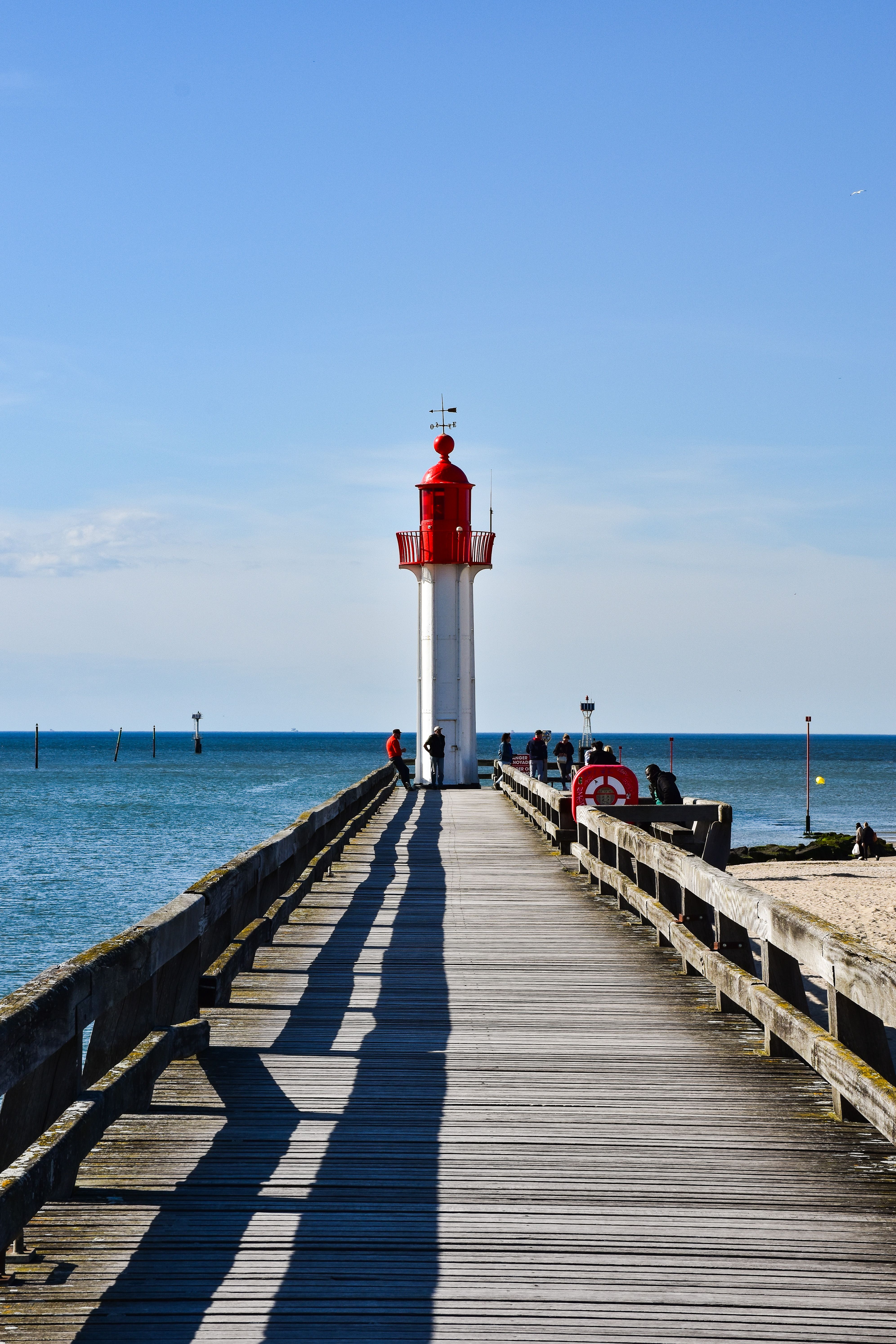A red and white lighthouse on a pier · Free Stock Photo