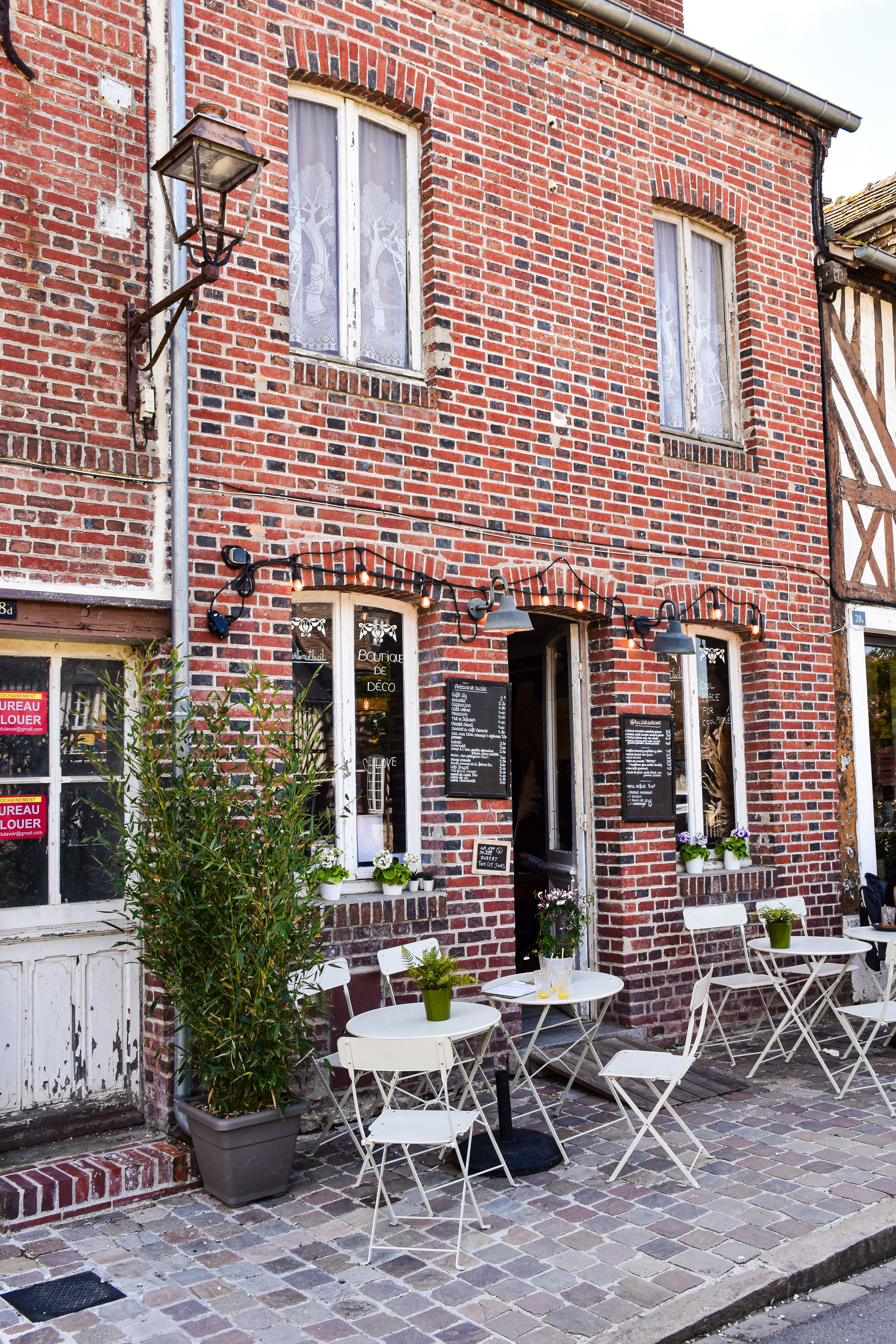 A brick building with tables and chairs outside · Free Stock Photo