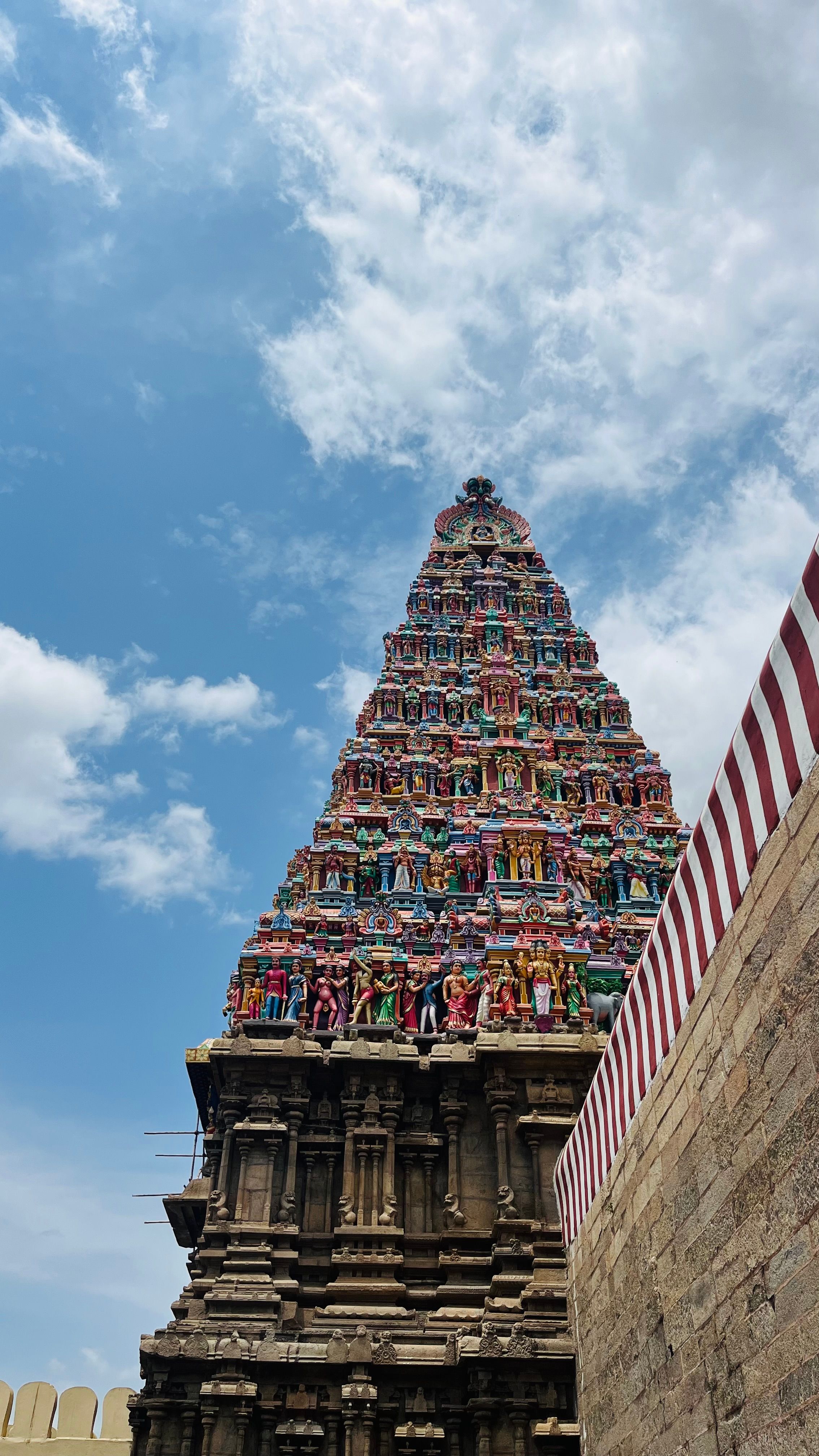 The tall spire of a temple is shown against a blue sky · Free Stock Photo