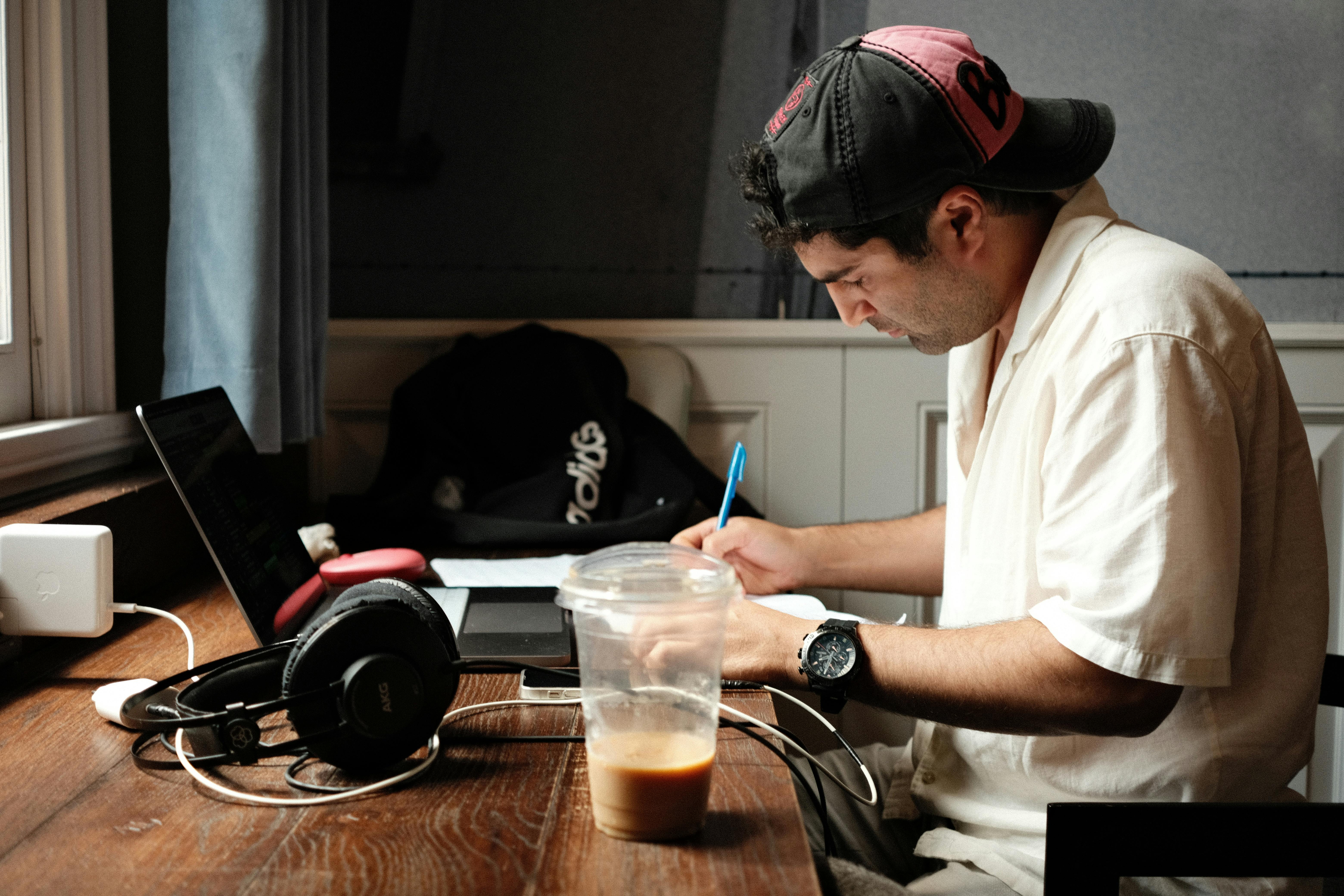 Man Using Laptop on Table Against White Background · Free Stock Photo