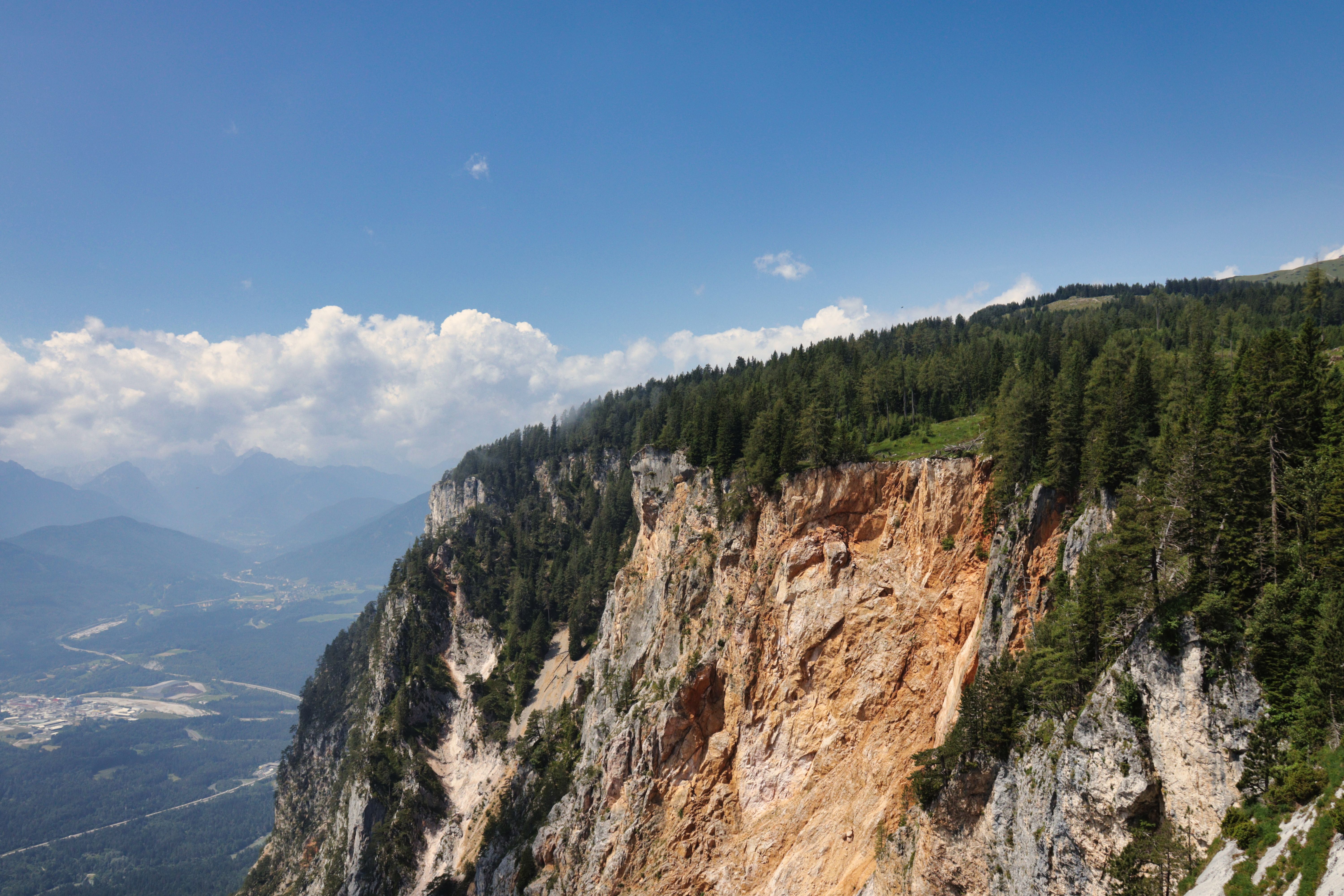 A cliff with a mountain in the background · Free Stock Photo