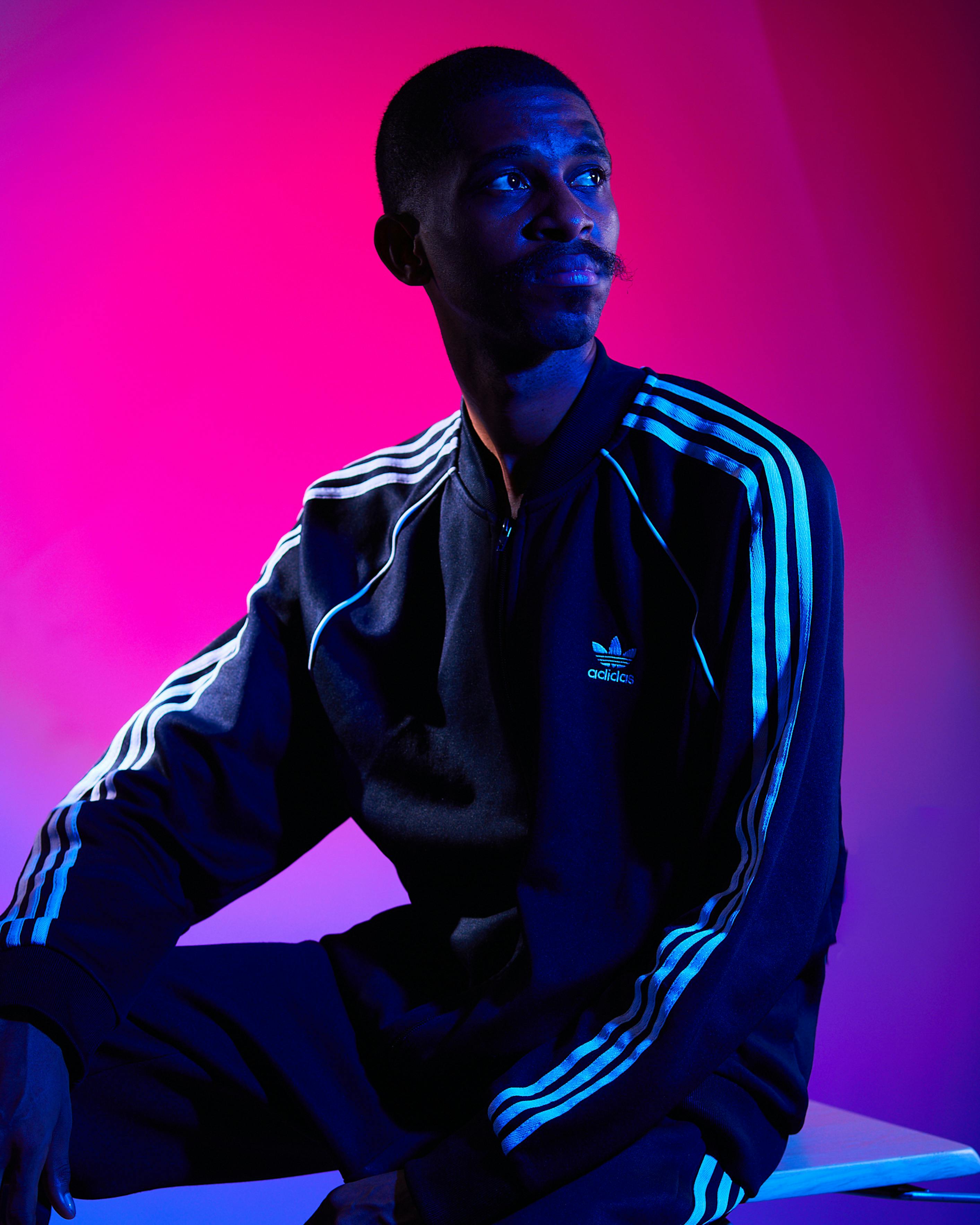 A man in adidas tracksuit sitting on a chair · Free Stock Photo