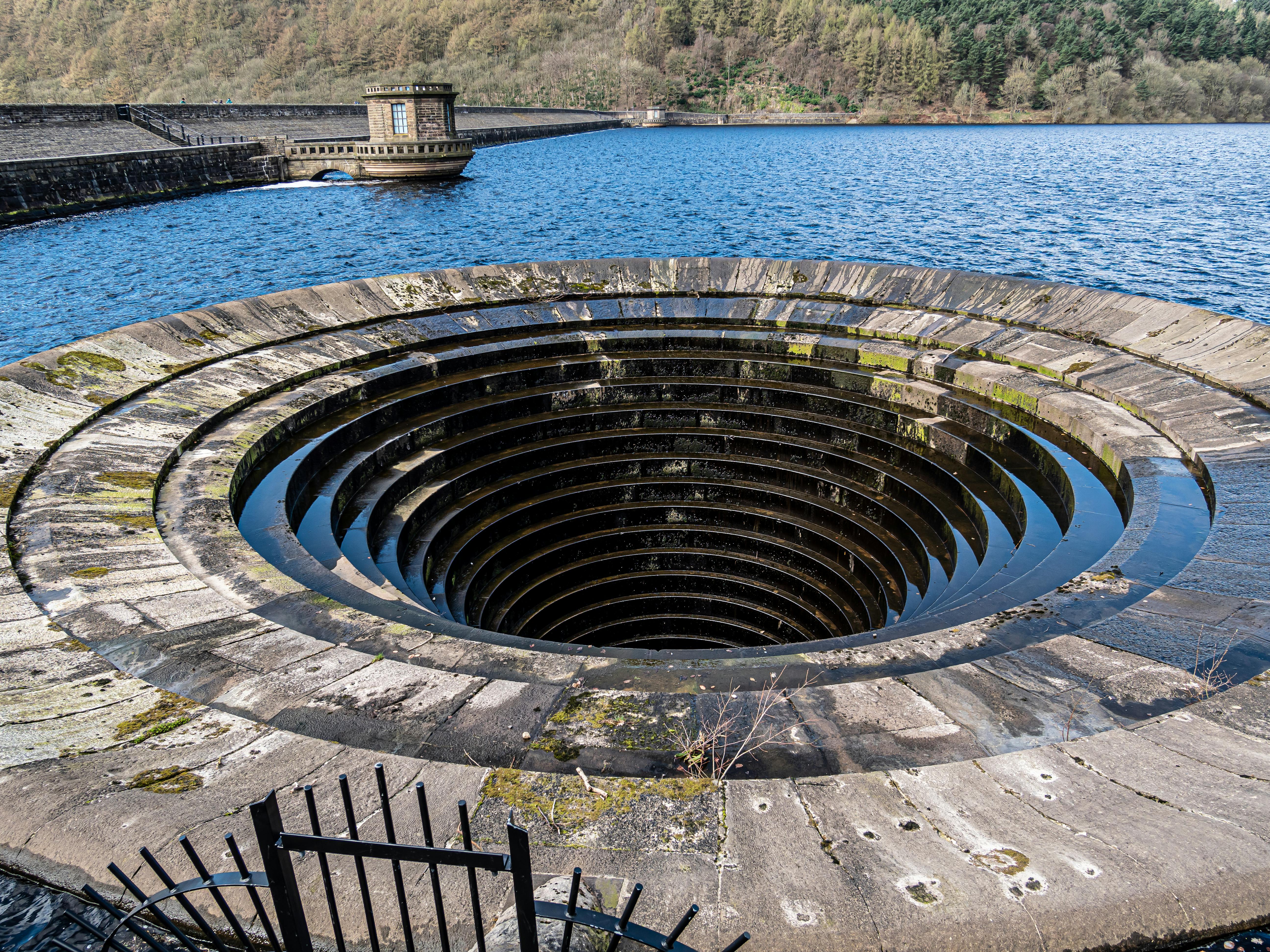 A circular hole in the ground with water flowing out of it · Free Stock ...