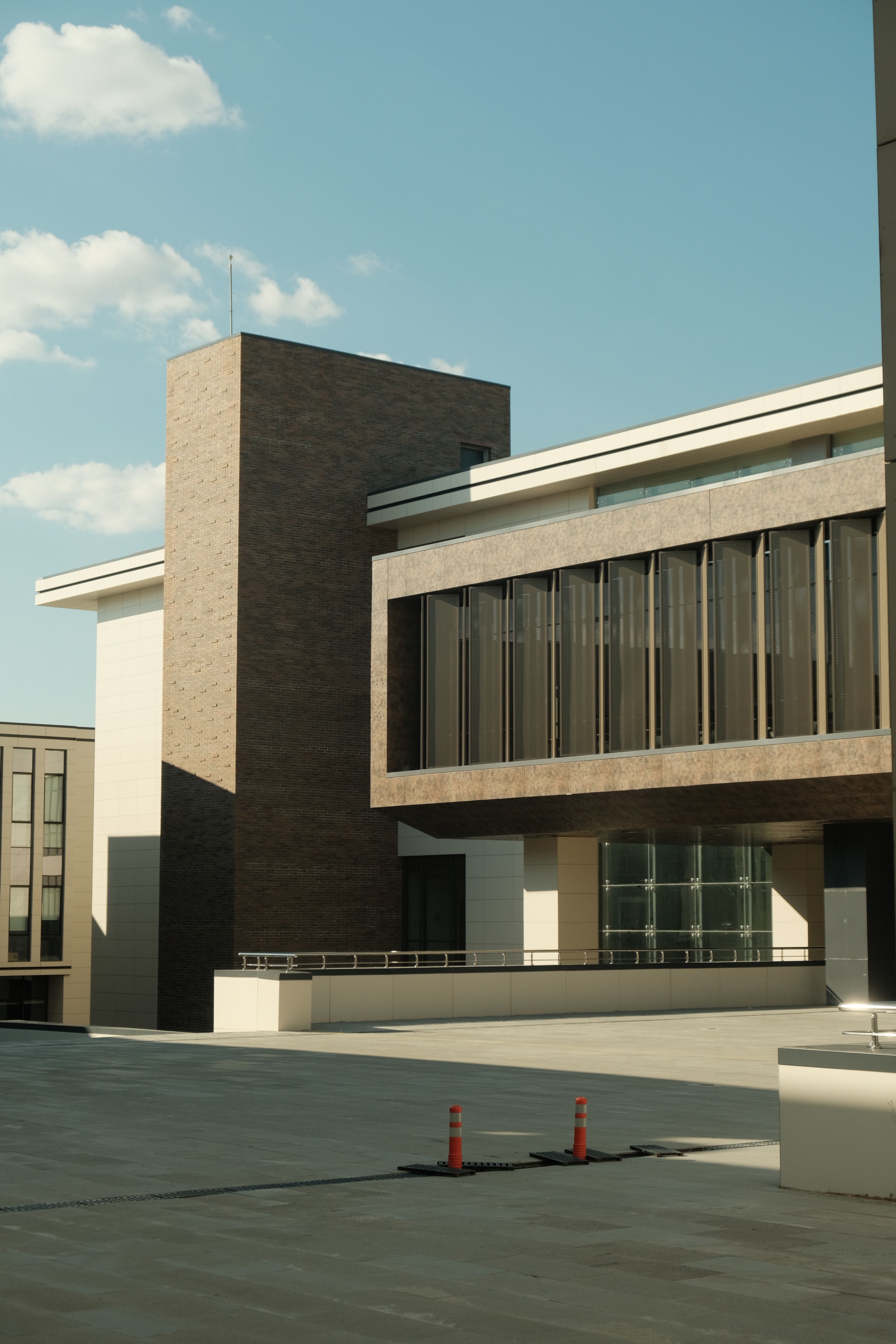 A building with a large glass window and a large parking lot · Free ...