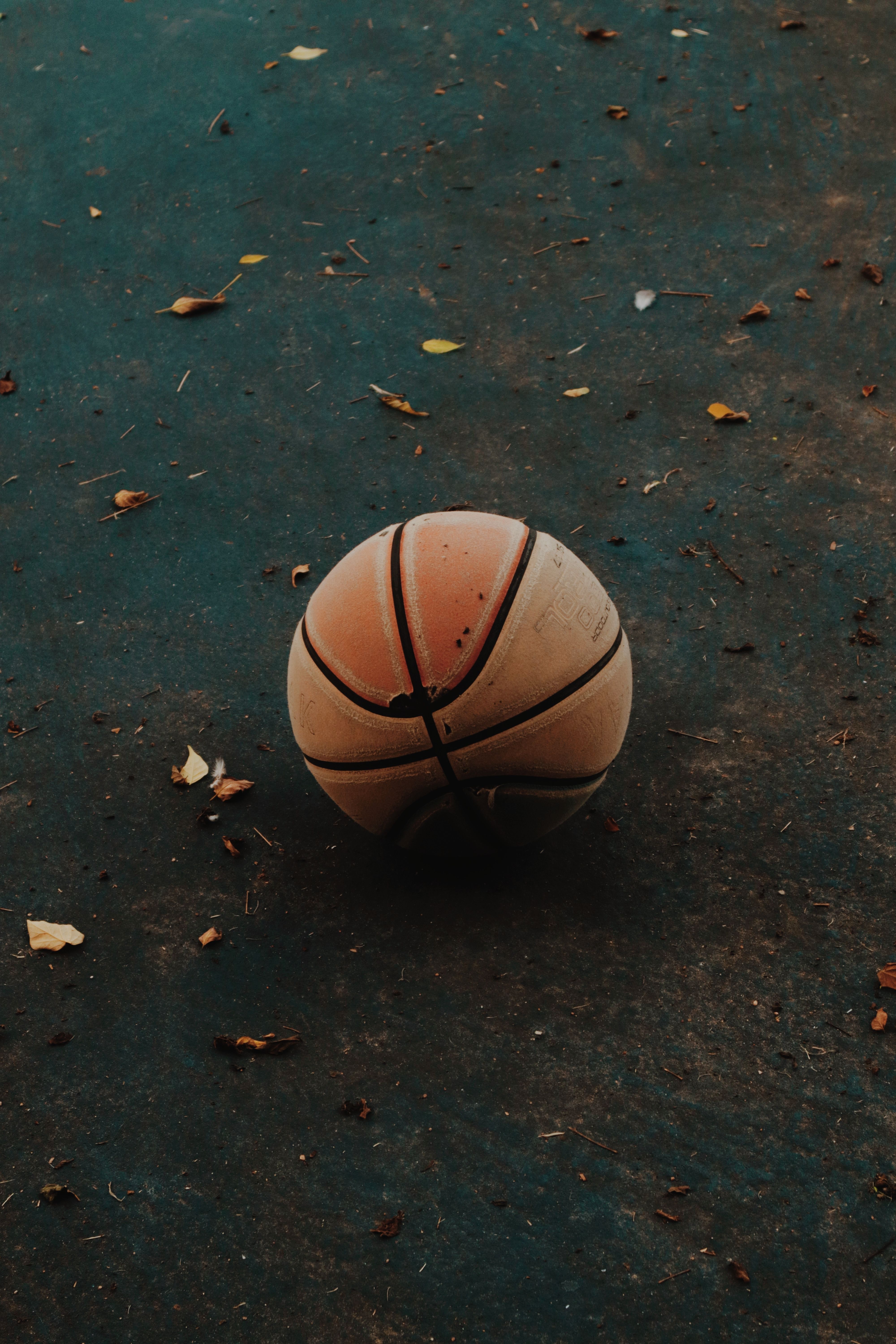 Lonely Basketball on Outdoor Court Through Fence · Free Stock Photo
