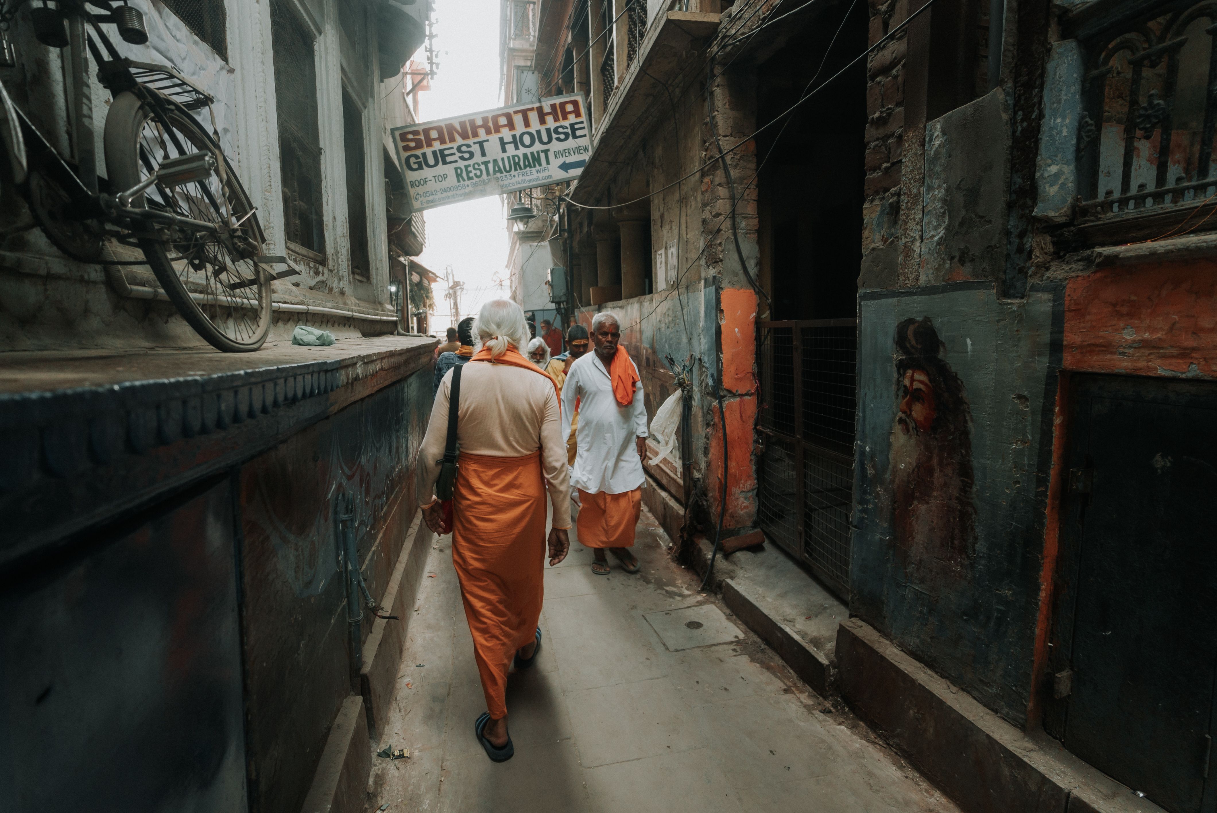 Two men walking down a narrow alleyway in india · Free Stock Photo