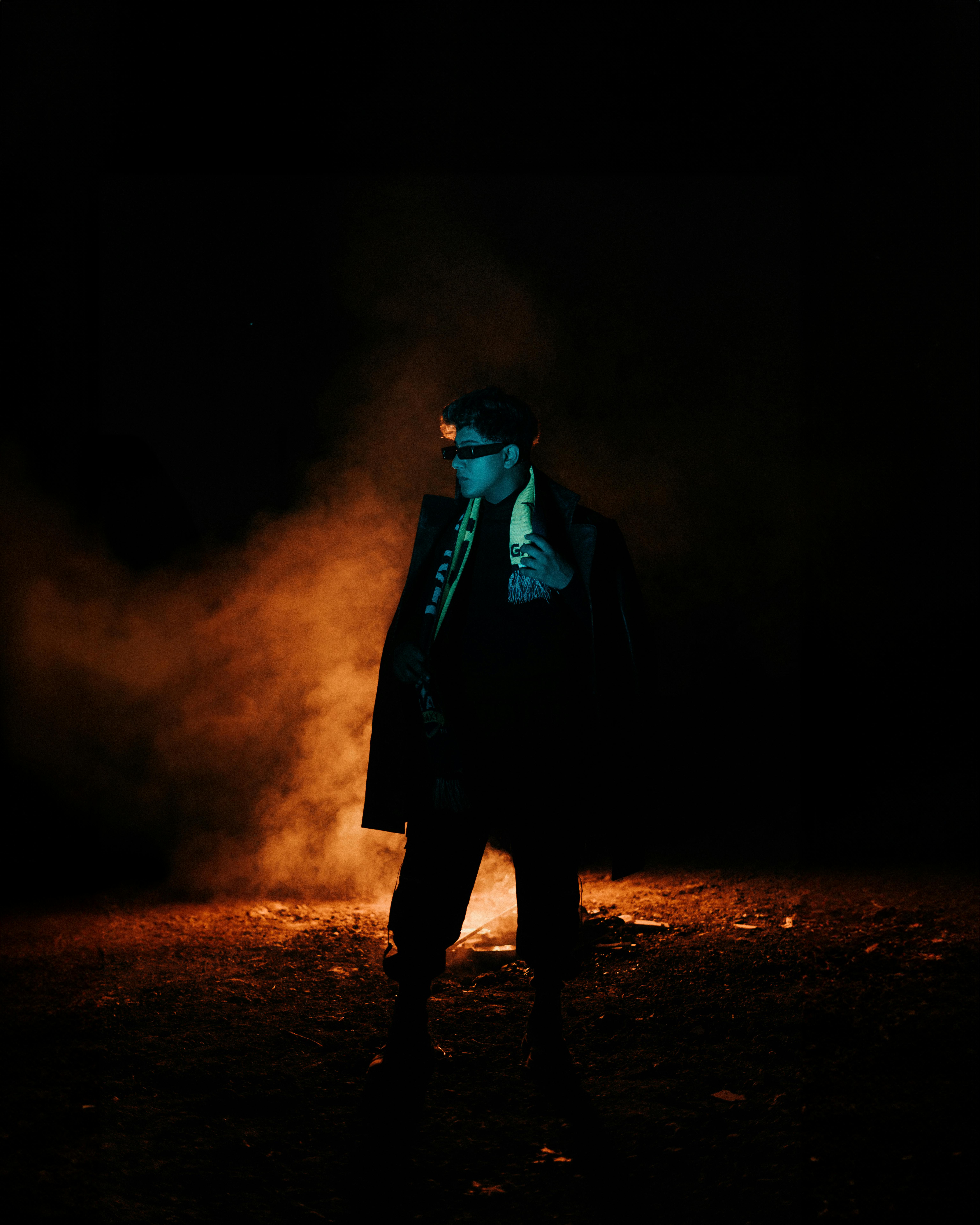 A man standing in front of a fire with smoke · Free Stock Photo