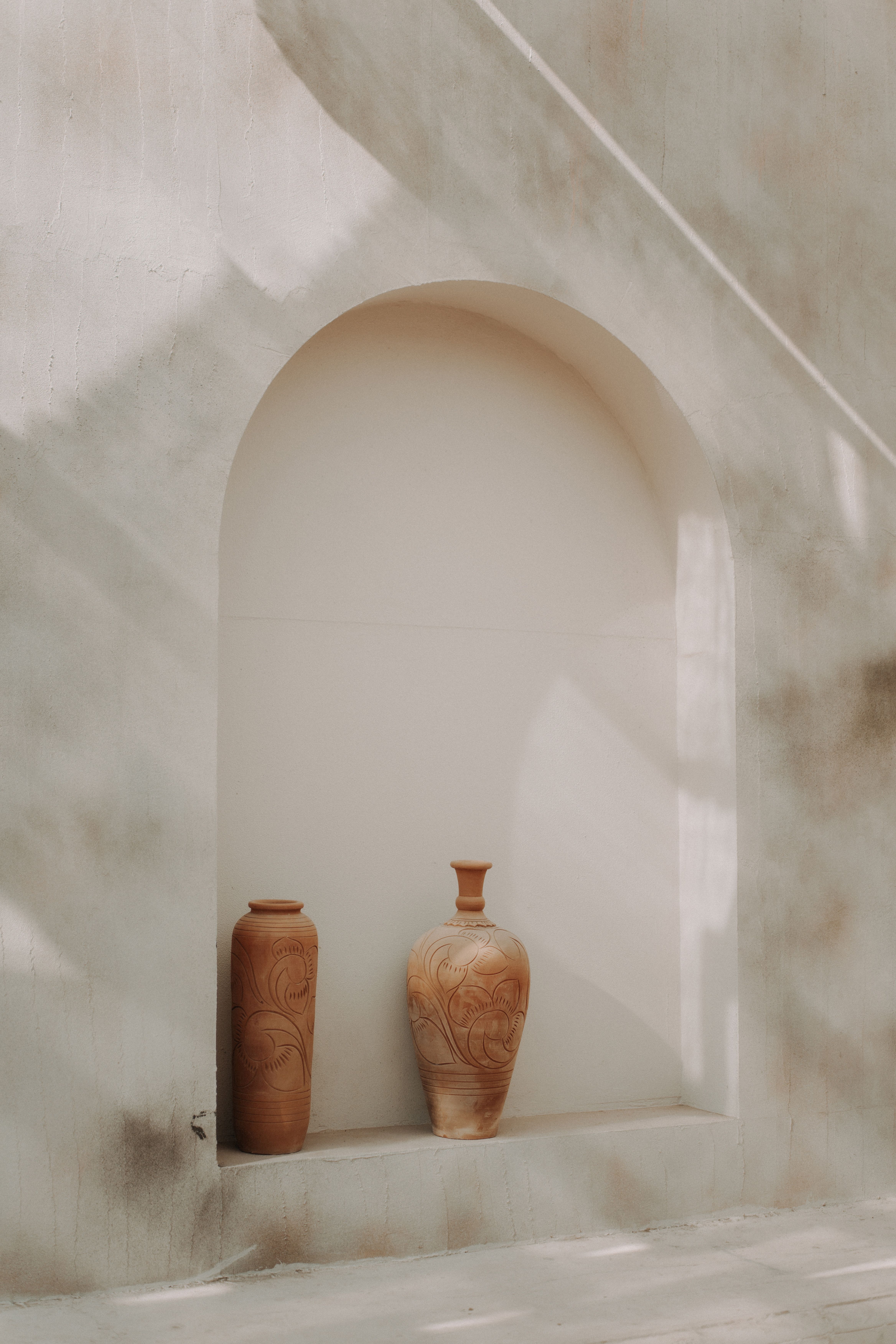 Two vases sit on a shelf in front of a window · Free Stock Photo