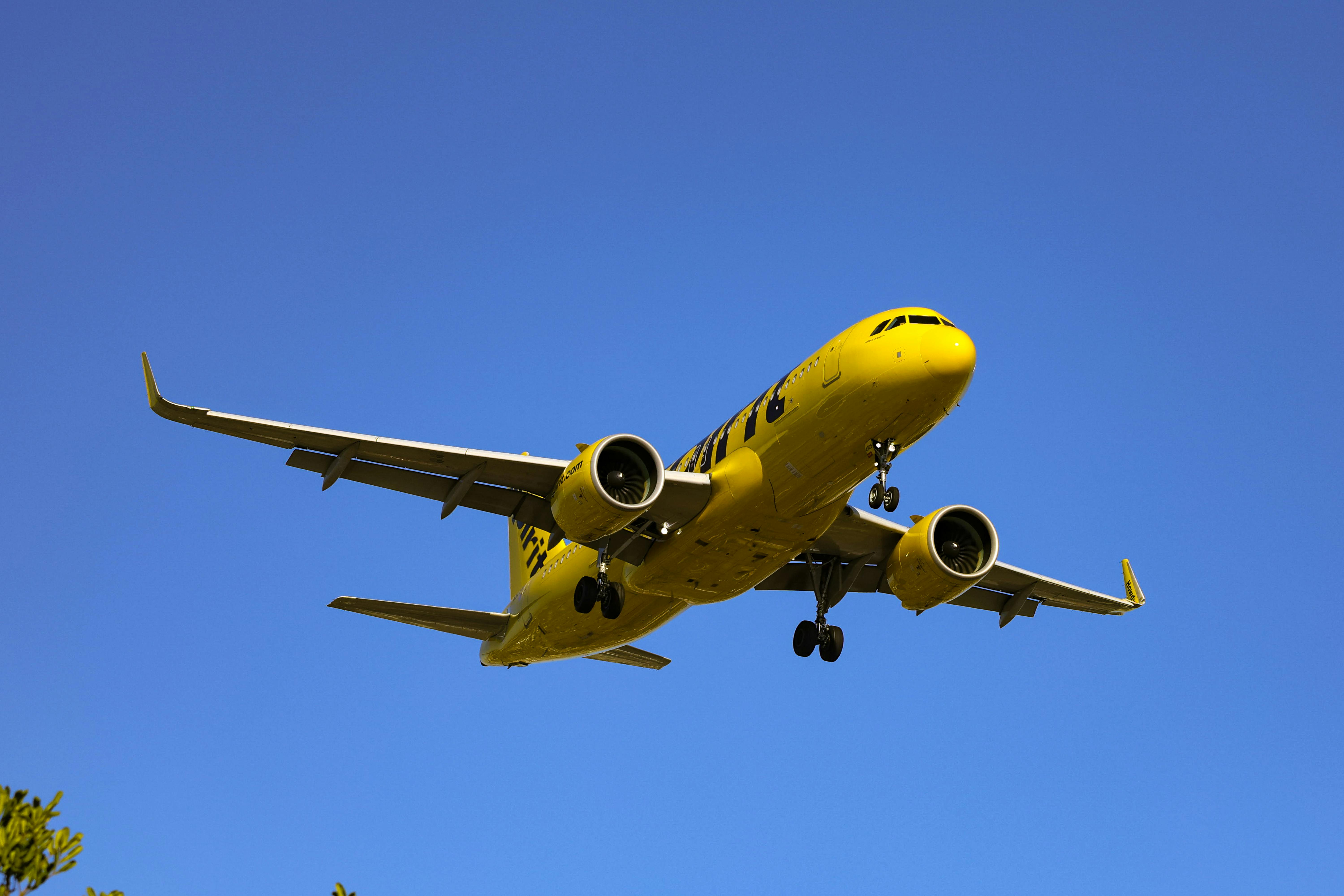 A yellow airplane flying in the sky · Free Stock Photo