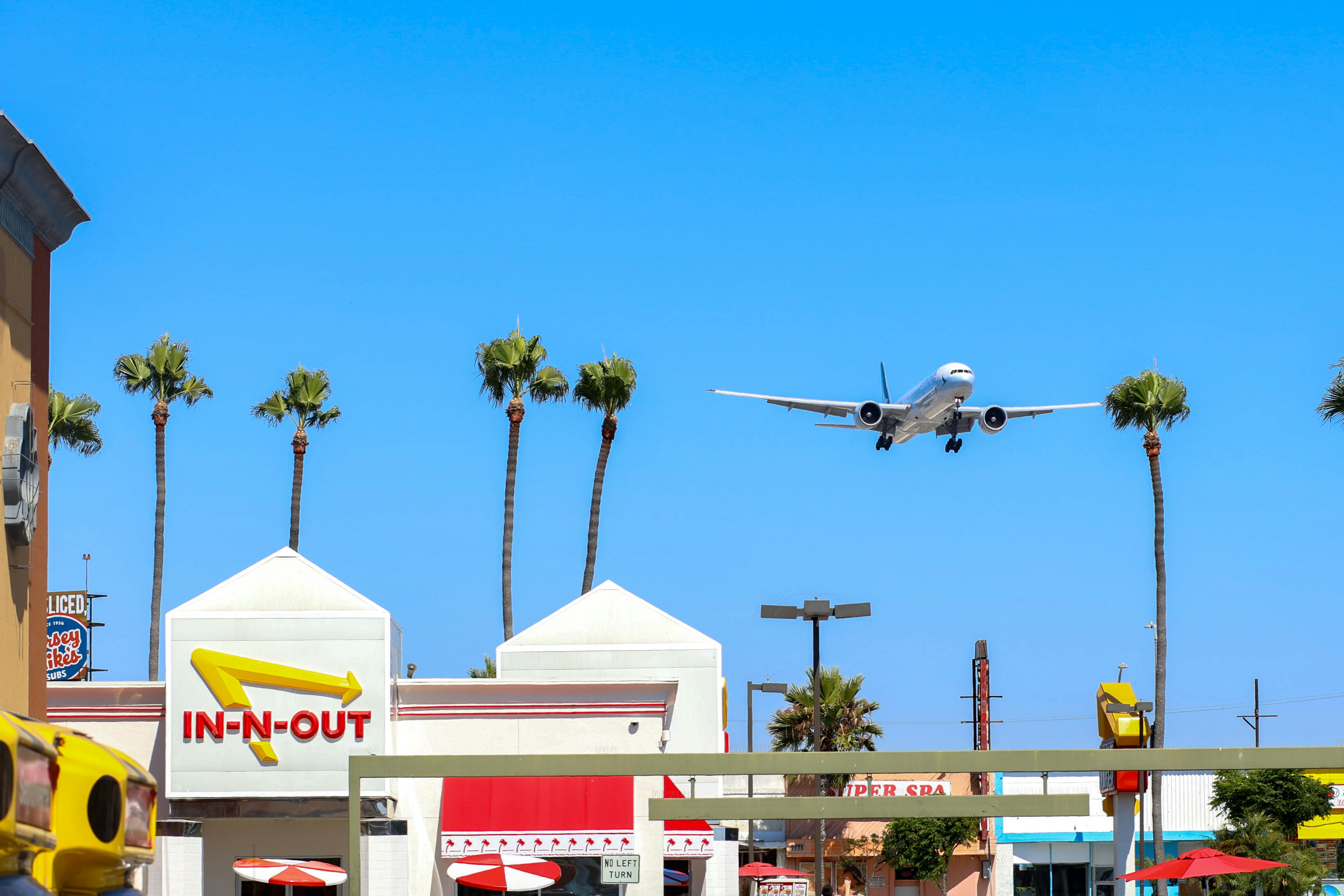 A plane flying over a fast food restaurant · Free Stock Photo