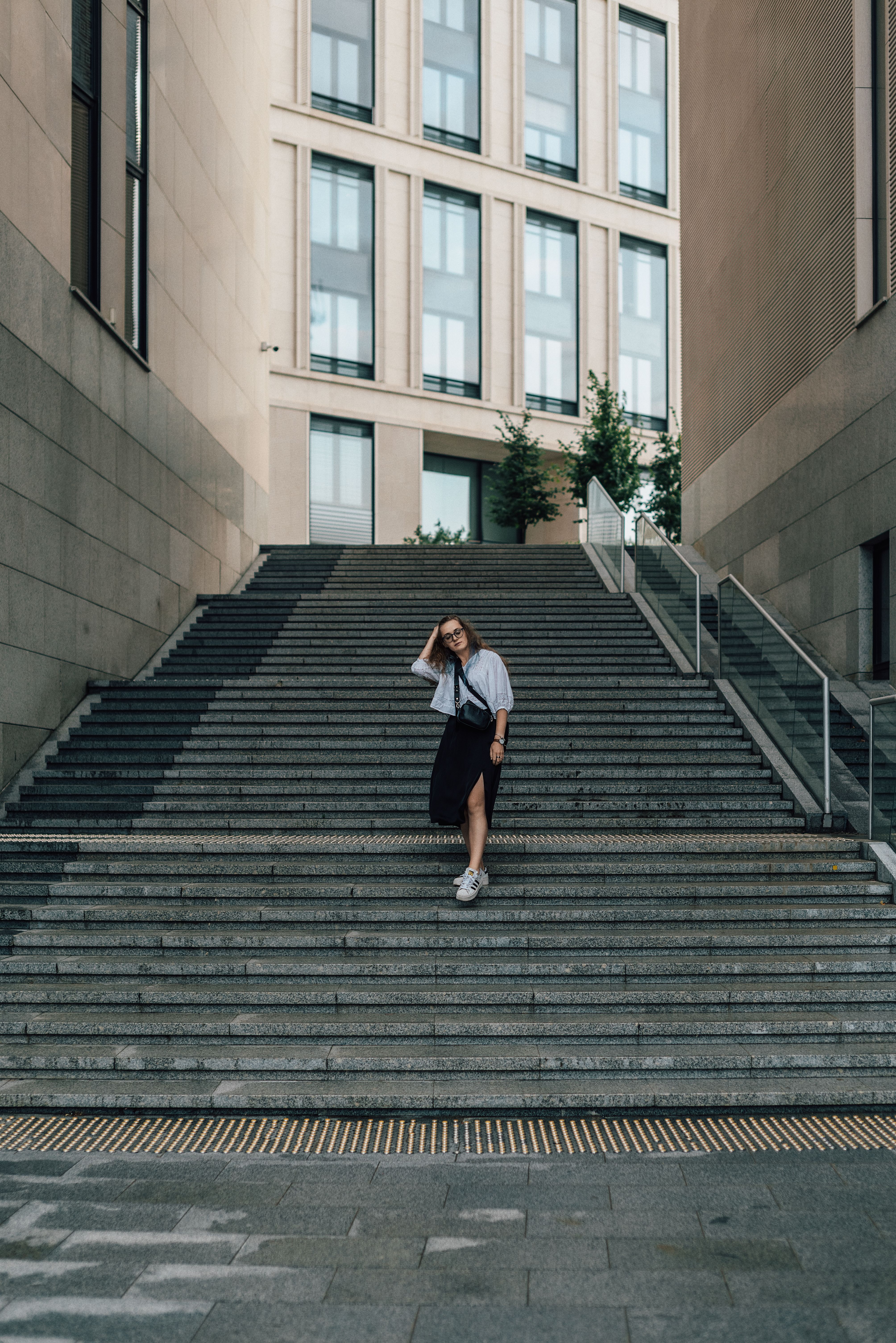 A woman walking down some stairs in front of a building · Free Stock Photo