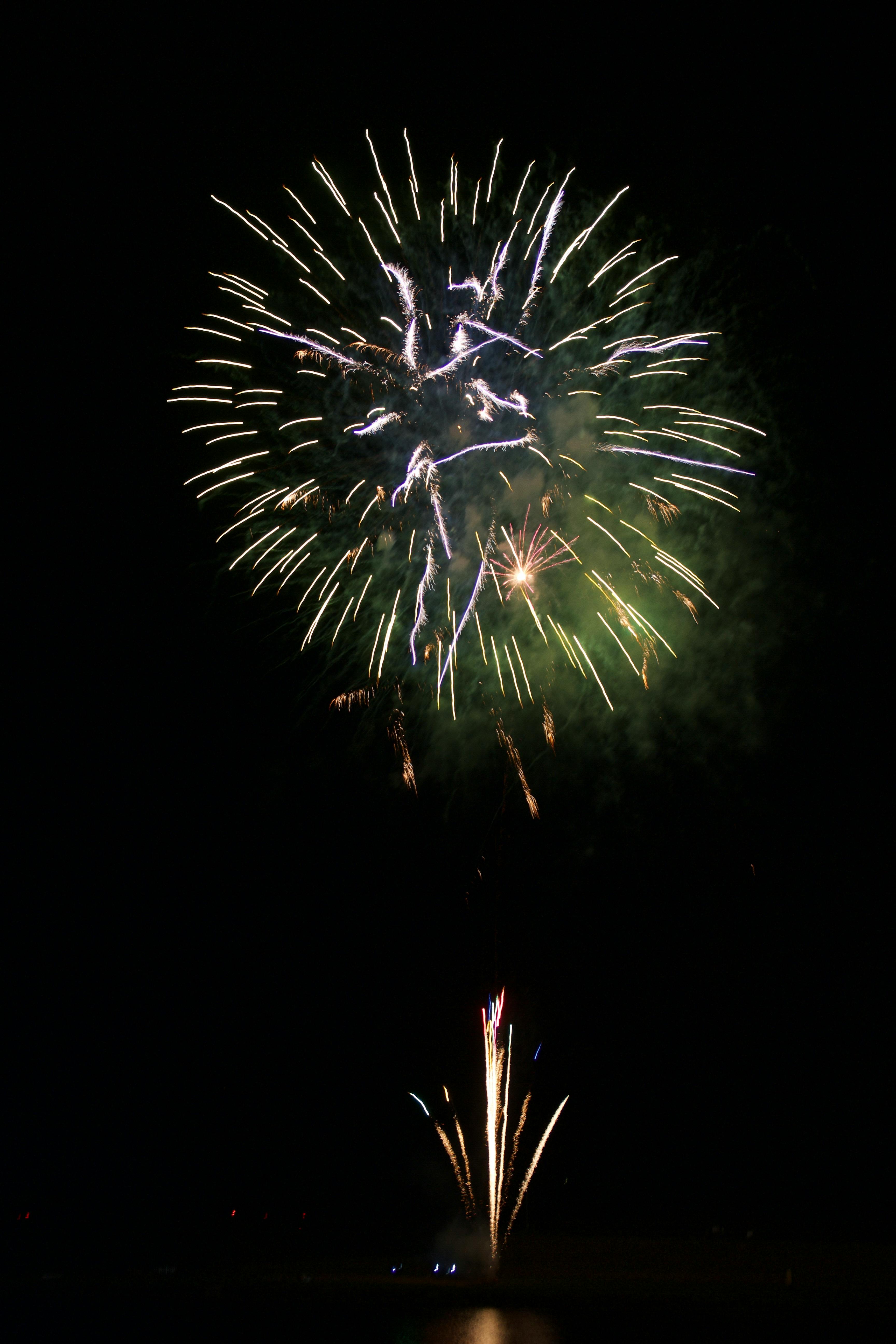 Fireworks over the water at night with a boat in the background · Free ...