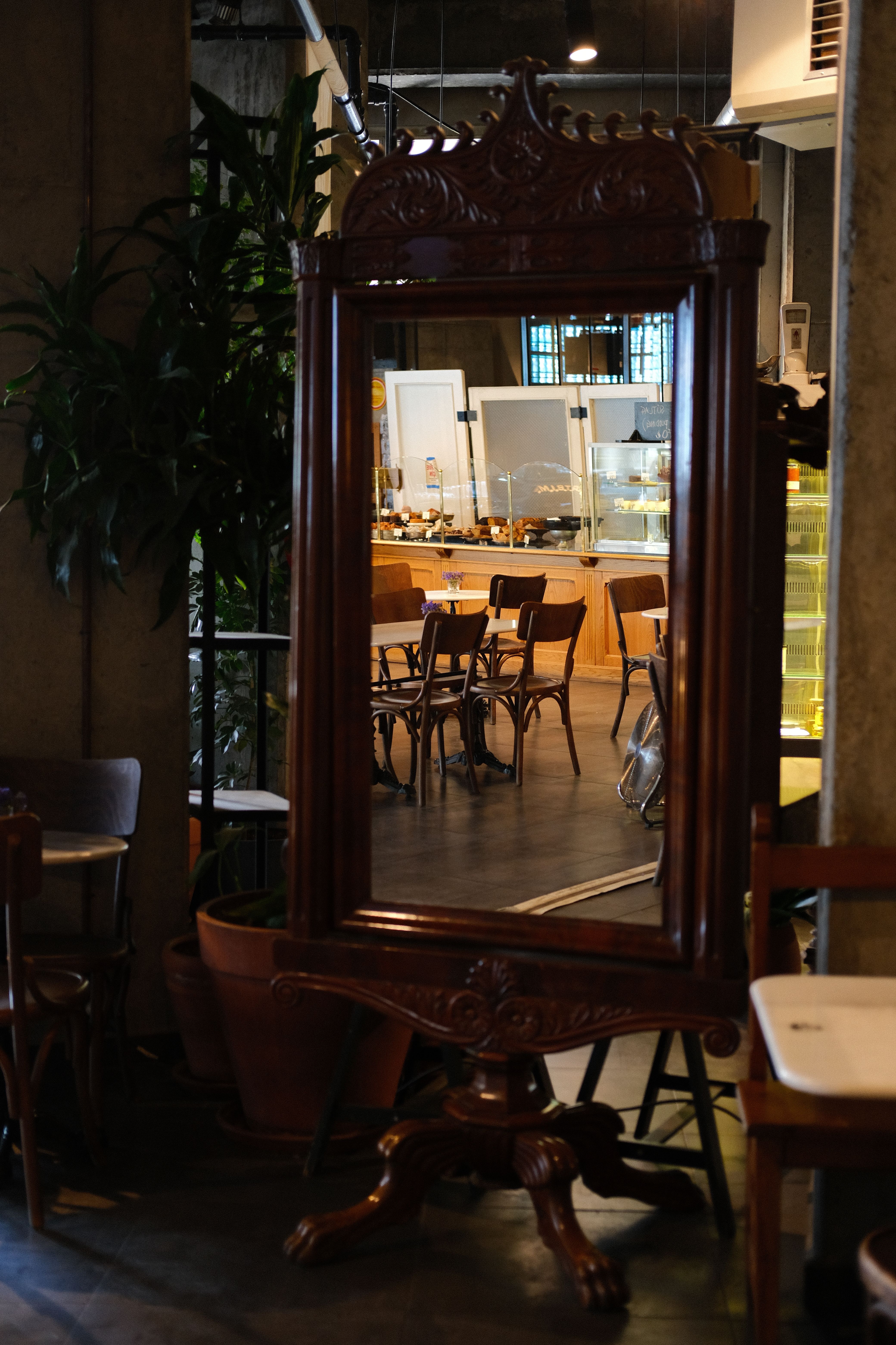 A mirror in a restaurant with tables and chairs · Free Stock Photo