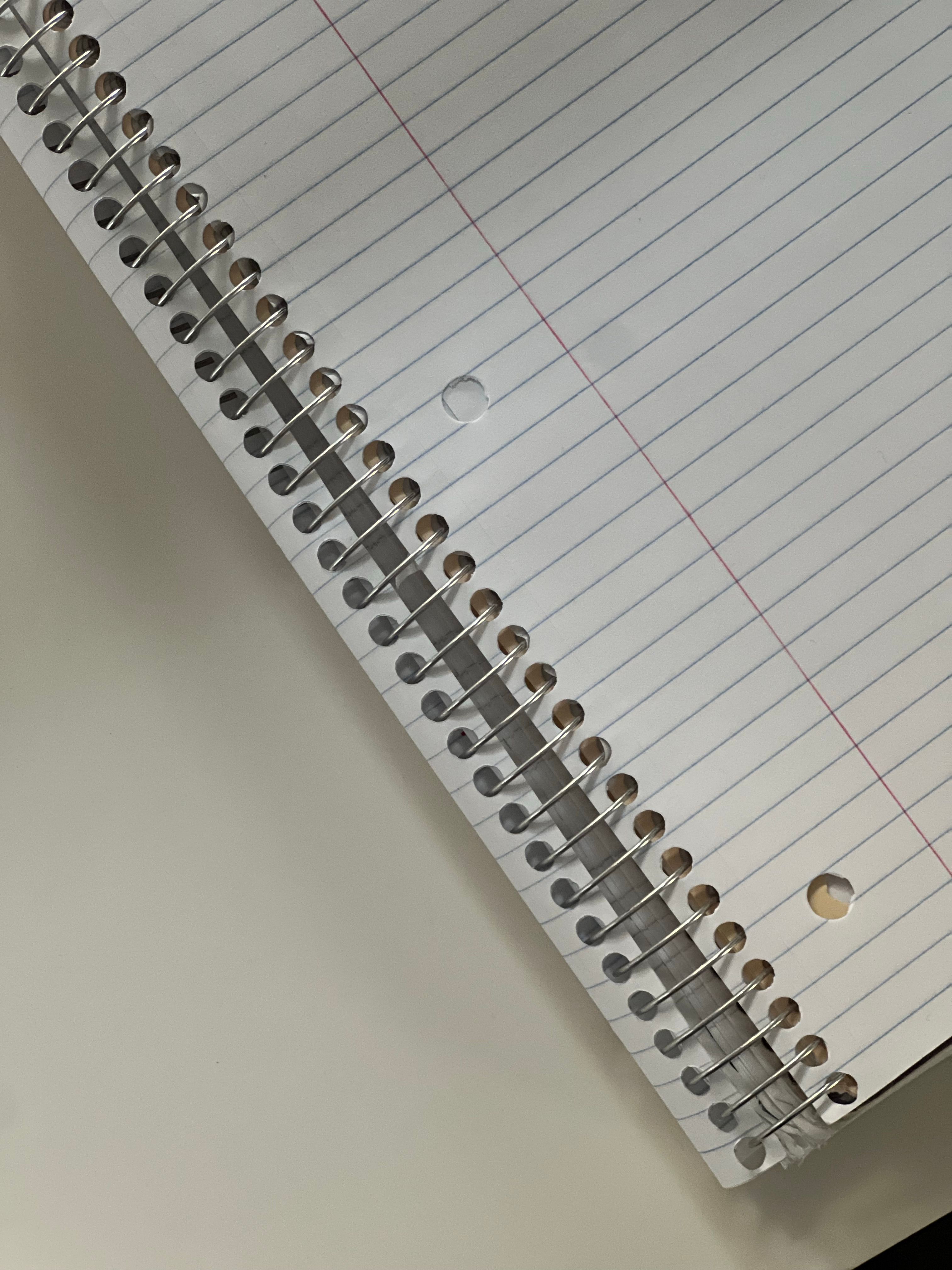 A spiral notebook with a hole in the middle · Free Stock Photo